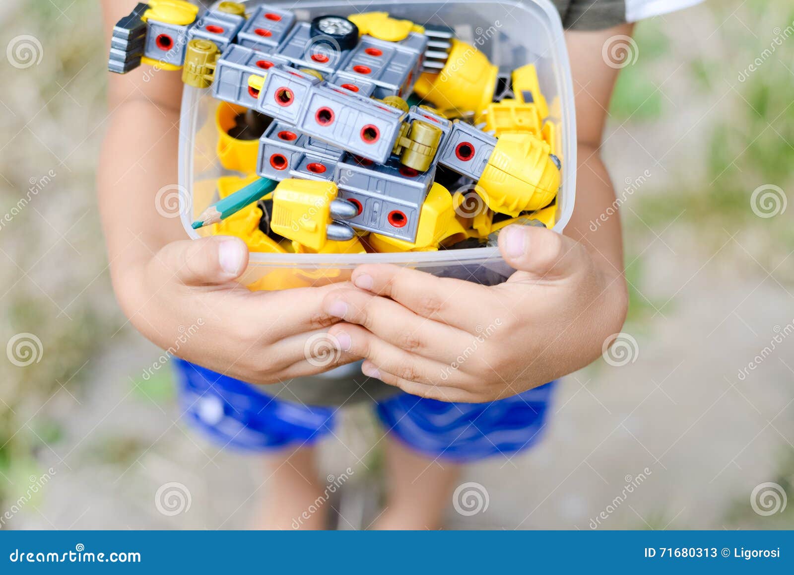 Child Holding Box with Toys on Outdoors Background Stock Image - Image ...