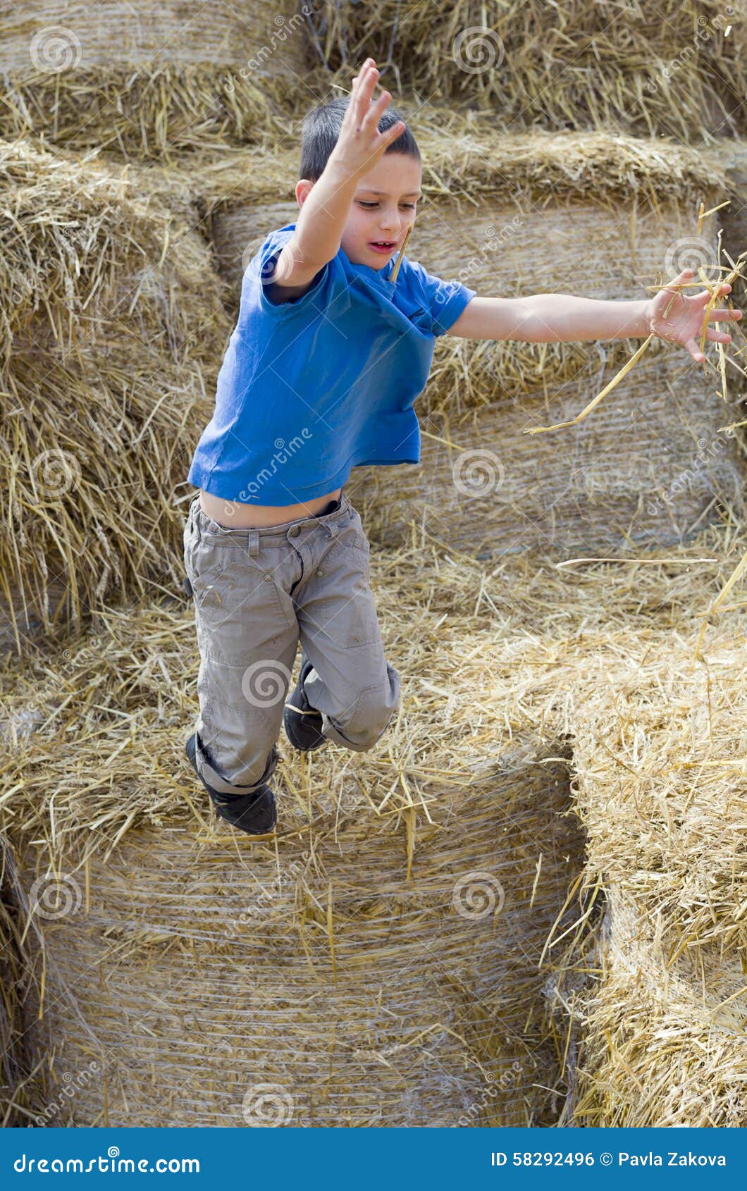 Child jumping in haystack stock photo. Image of throw - 58292496