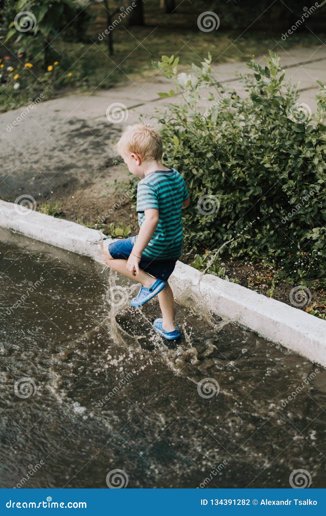 Little Boy Jumping in a Puddle in Summer Stock Photo - Image of ...