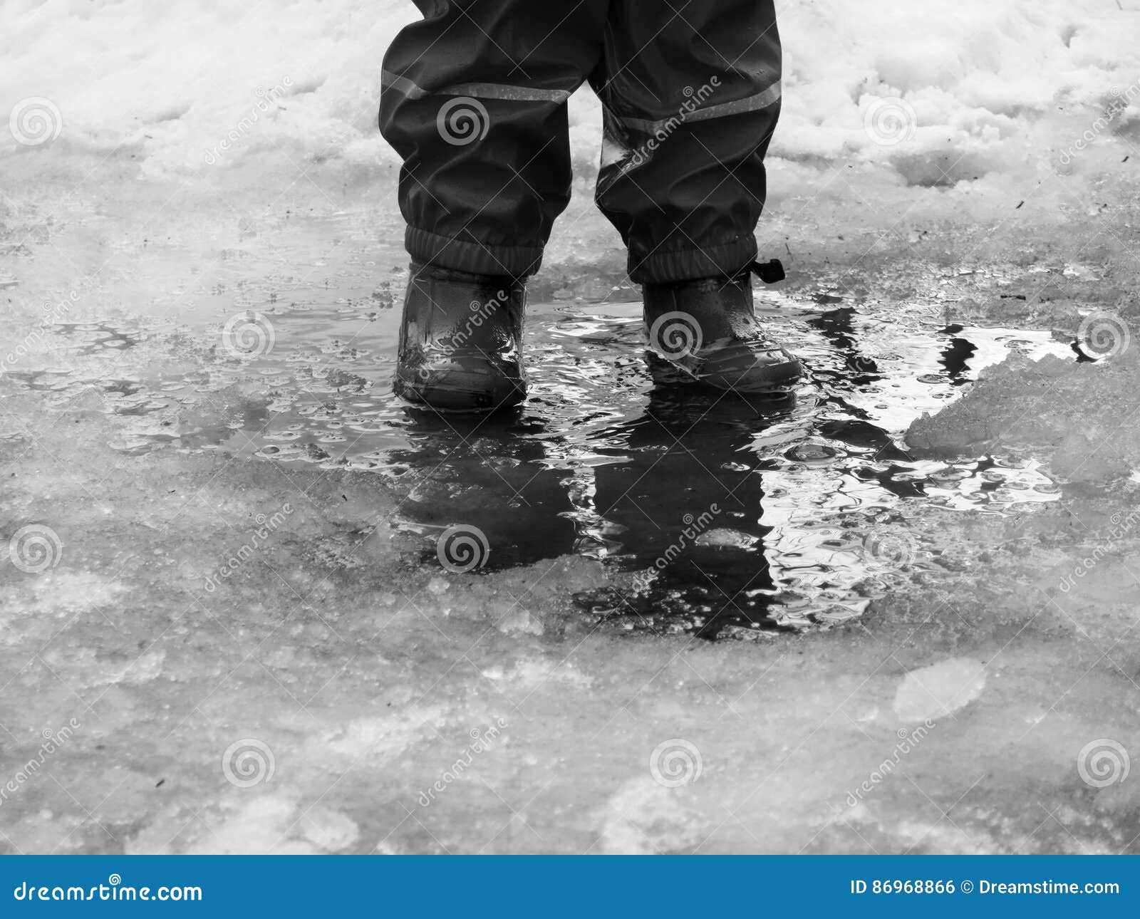 Child Jumping for Puddles on the Roads Thaw in the End of Winter Stock ...