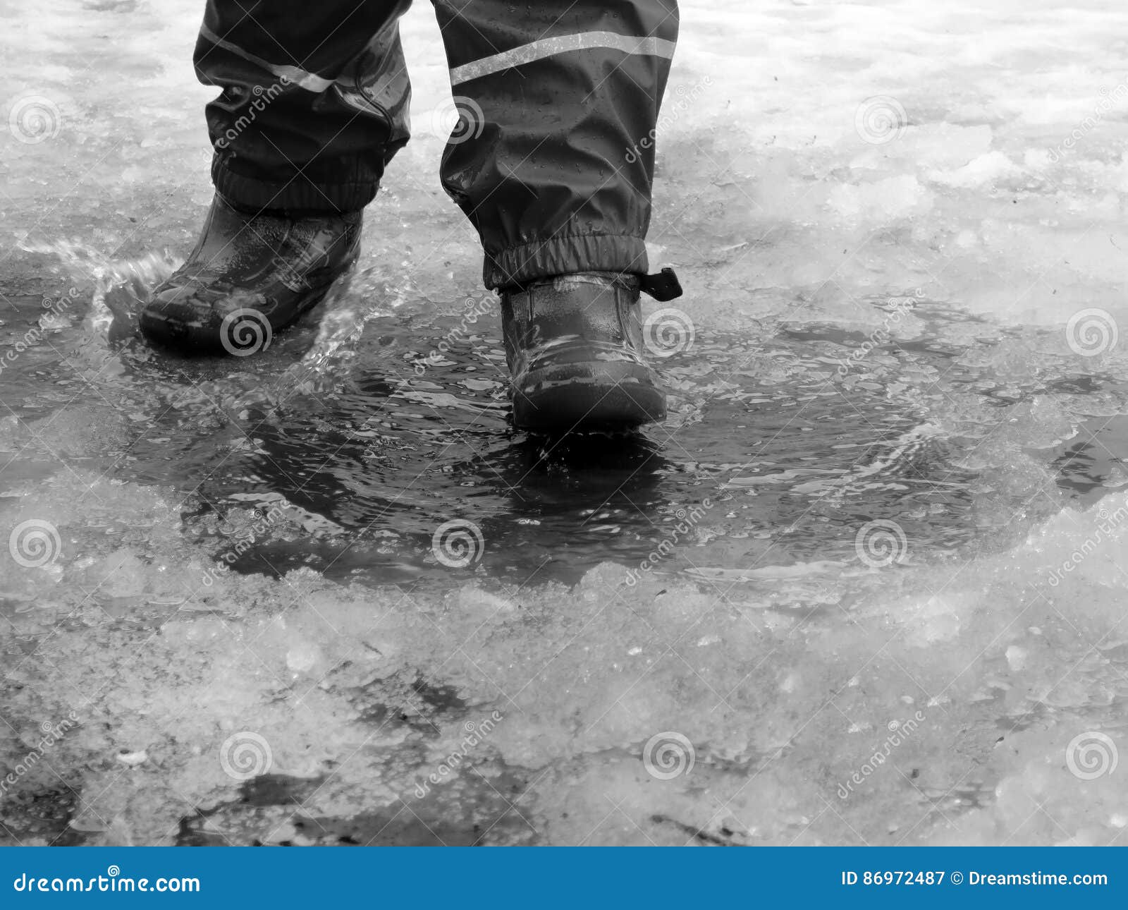 Child Jumping for Puddles on the Roads Thaw in the End of Winter Stock ...
