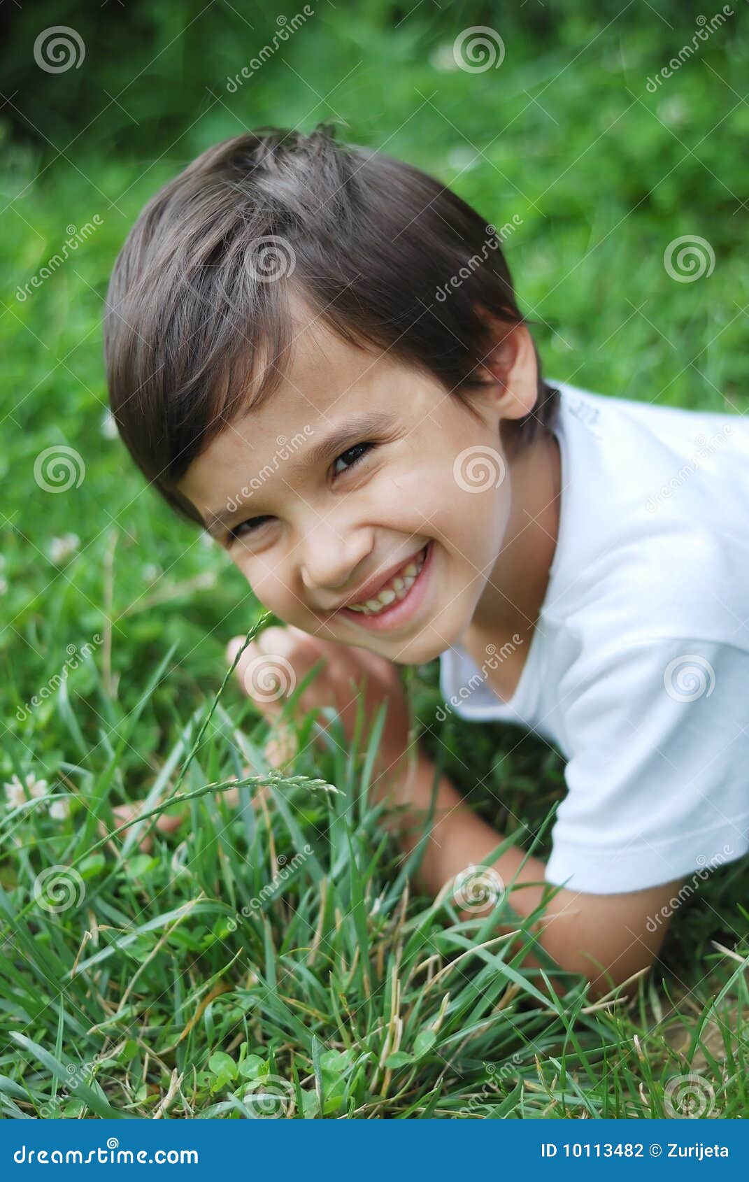 Child laying on the grass stock photo. Image of green - 10113482