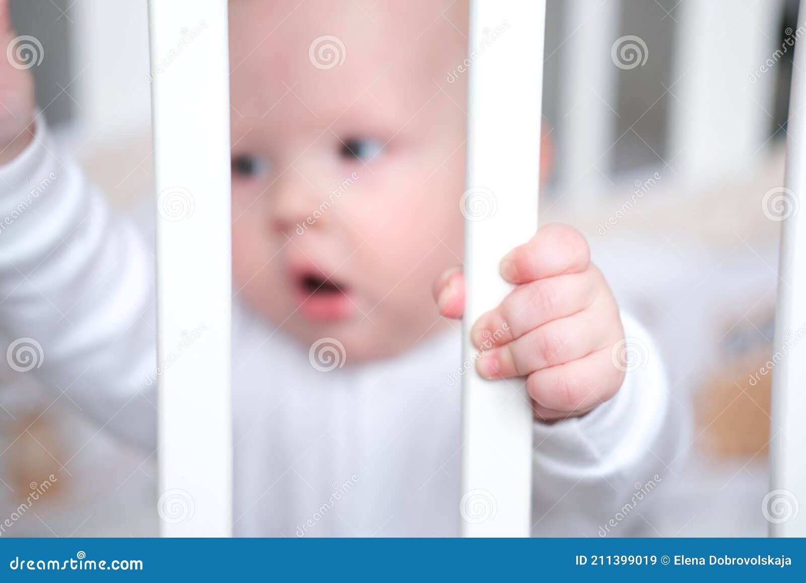 The Child Learns To Walk in a Crib and Takes the First Steps Stock ...