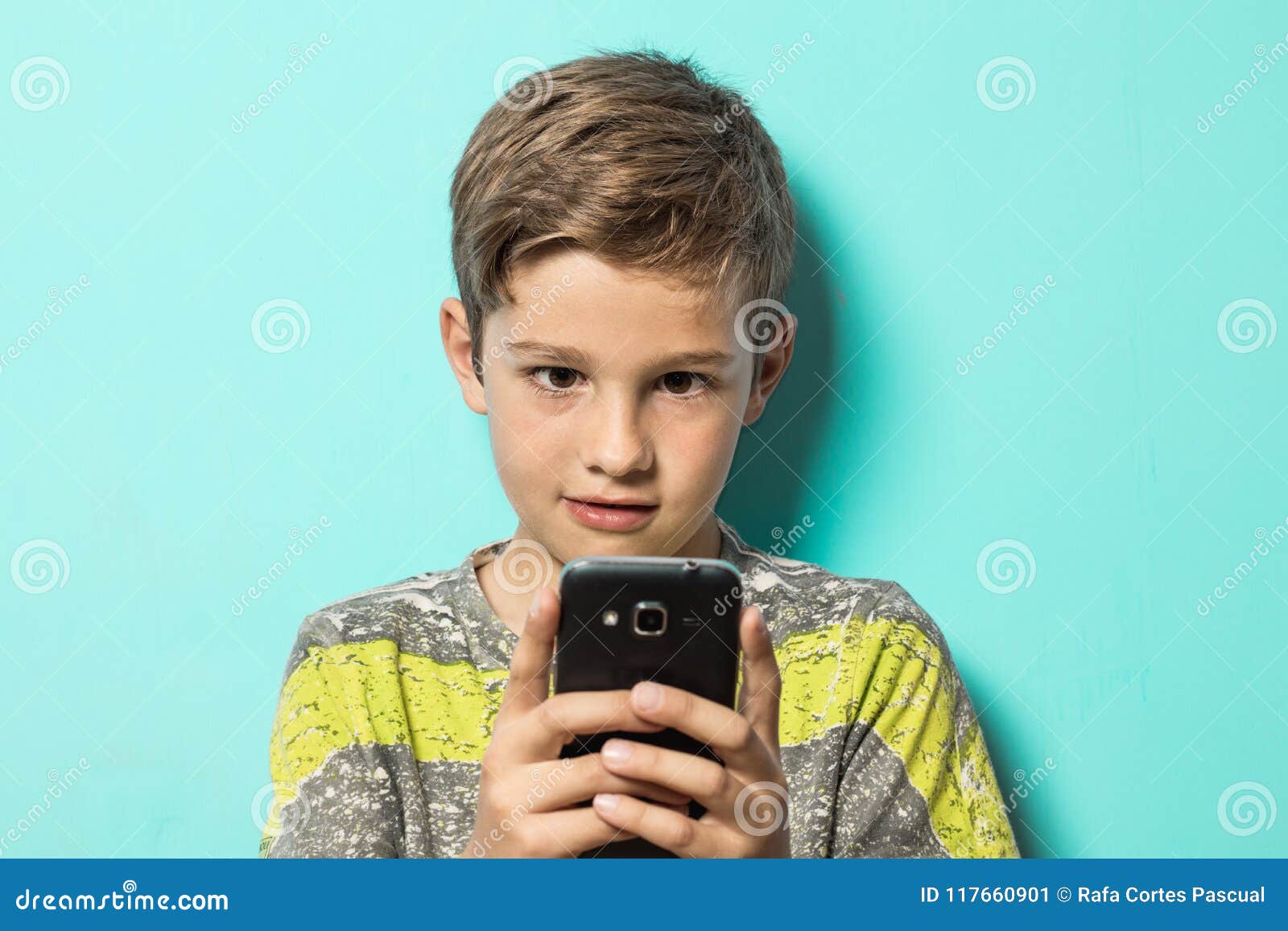 Child Looking at a Cell Phone with a Surprised Look on His Face Stock ...