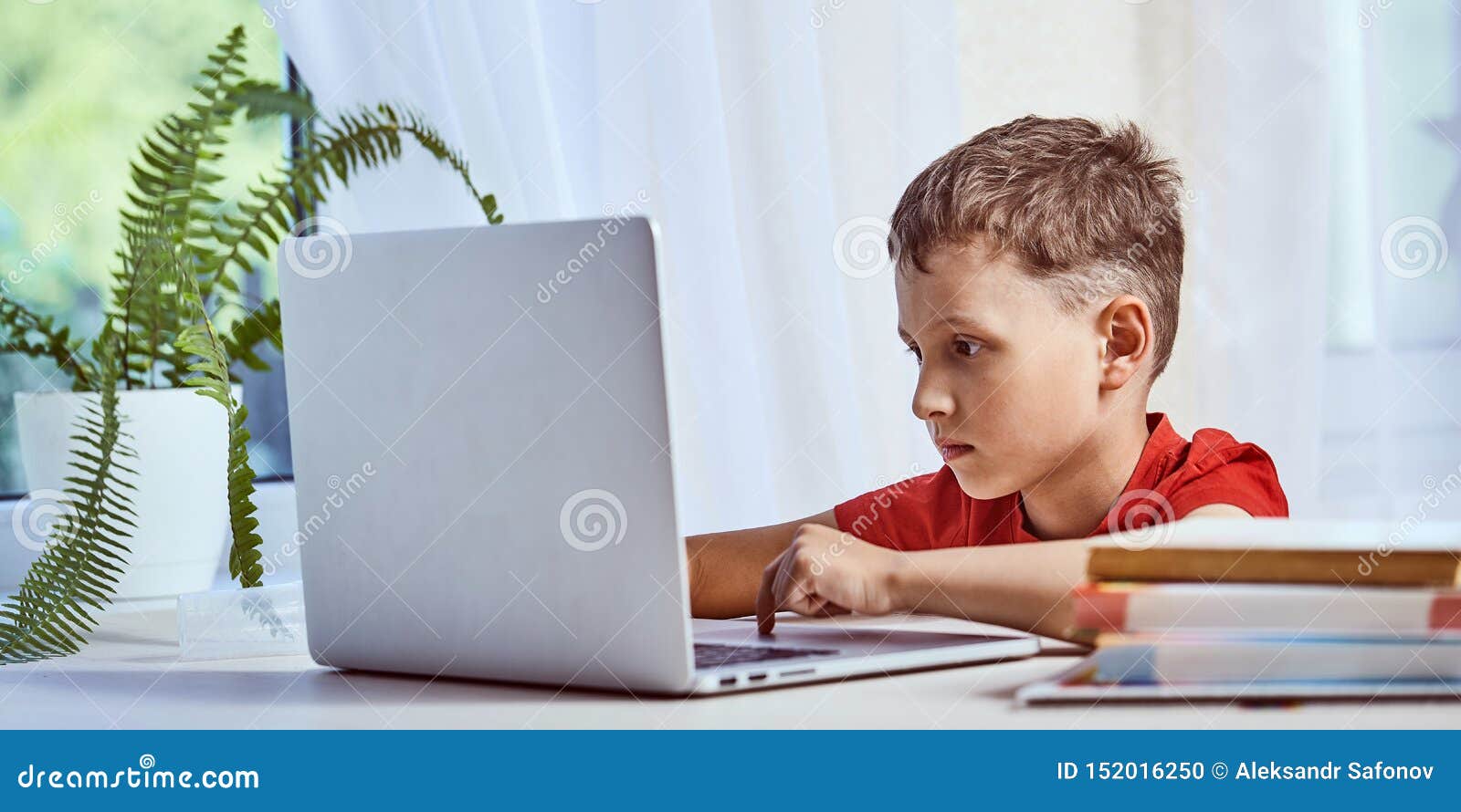 Child is Looking for Information on the Internet through a Laptop. Self ...