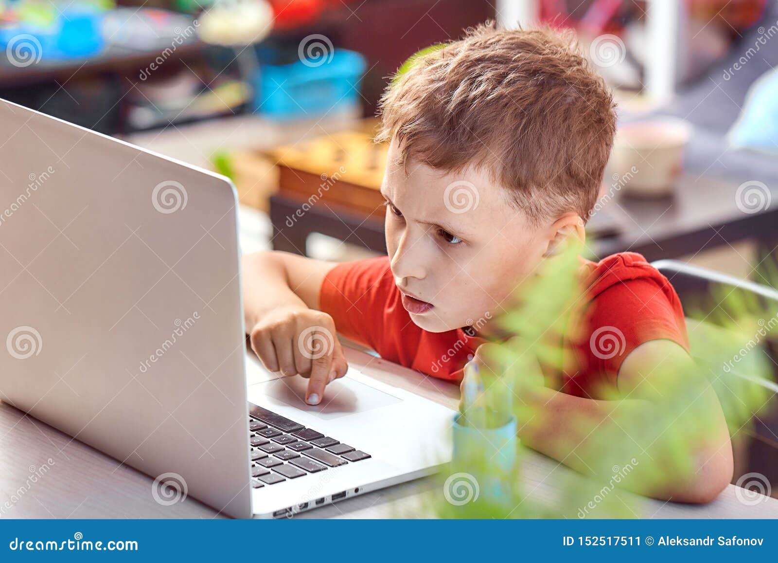 Child is Looking for Information on the Internet through a Laptop. Self ...