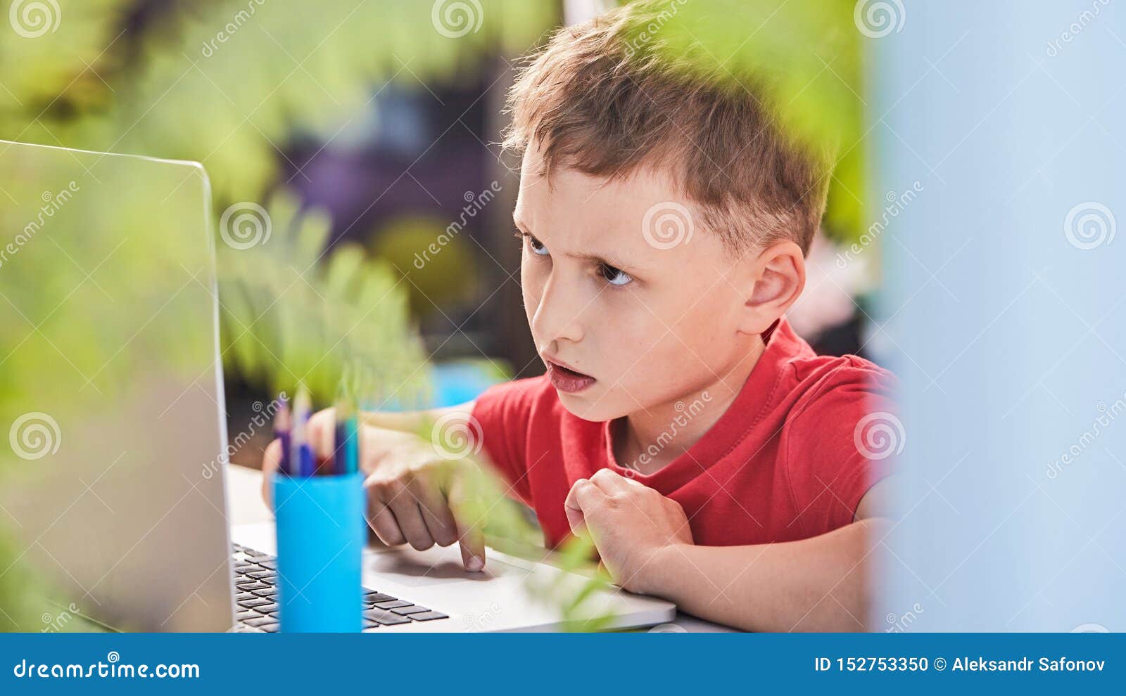 Child is Looking for Information on the Internet through a Laptop. Self ...