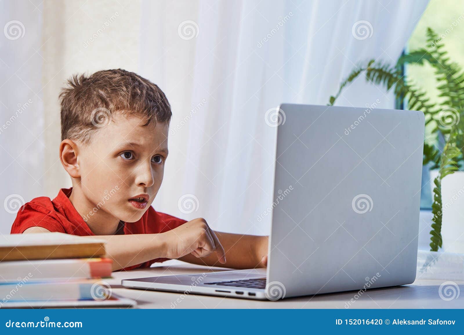 Child is Looking for Information on the Internet through a Laptop. Self ...
