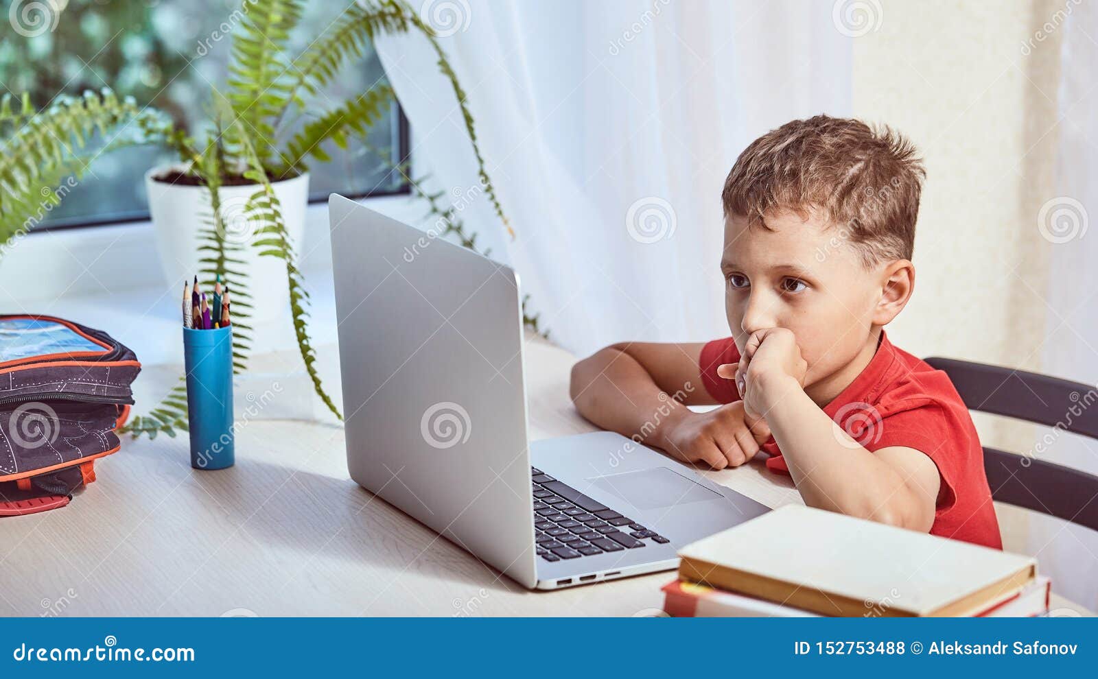 Child is Looking for Information on the Internet through a Laptop. Self ...
