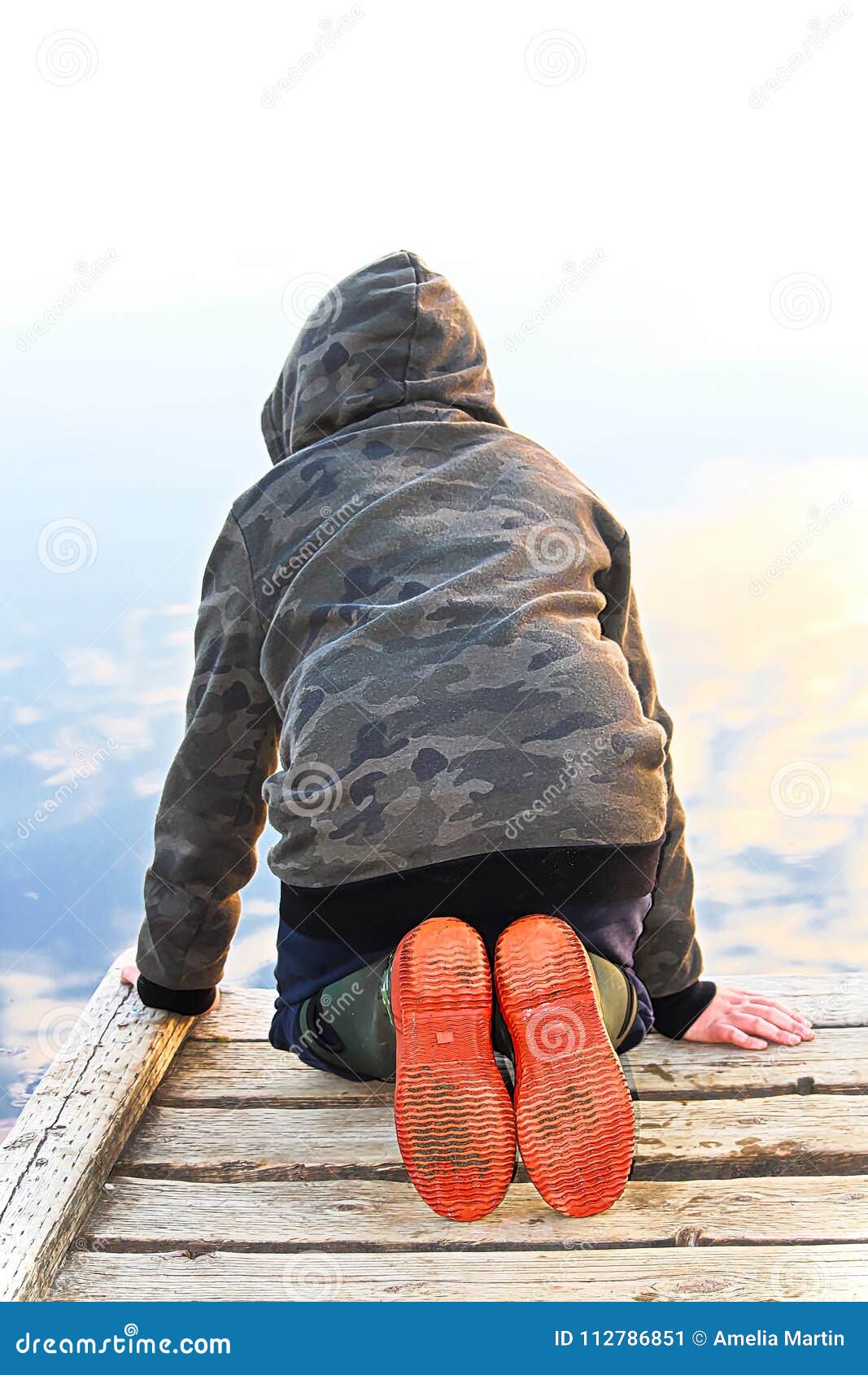 A Child Looking into Water with a Mirror Reflection of the Sky Stock ...