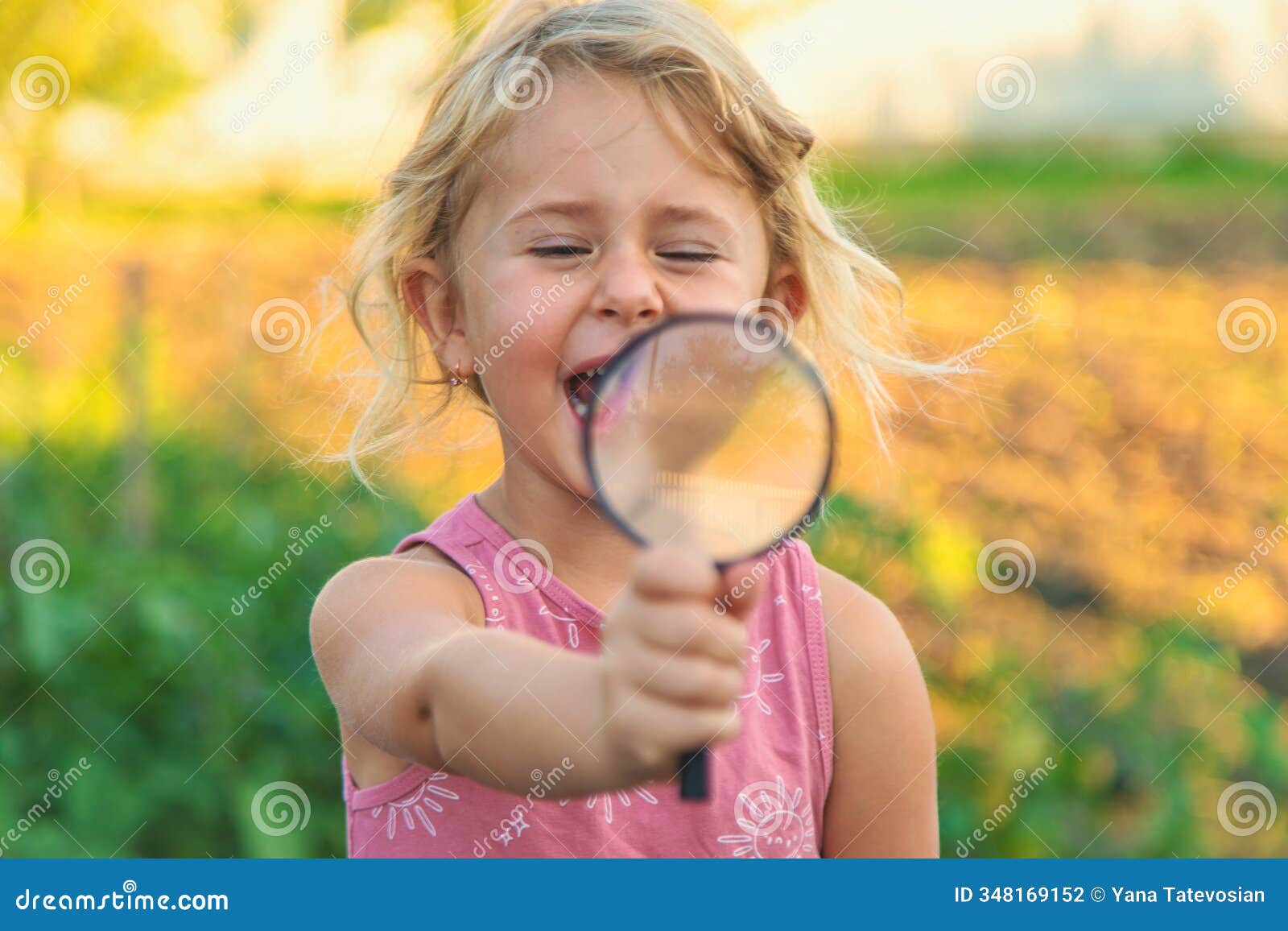 A Child Looks through a Magnifying Glass in Nature. Selective Focus ...