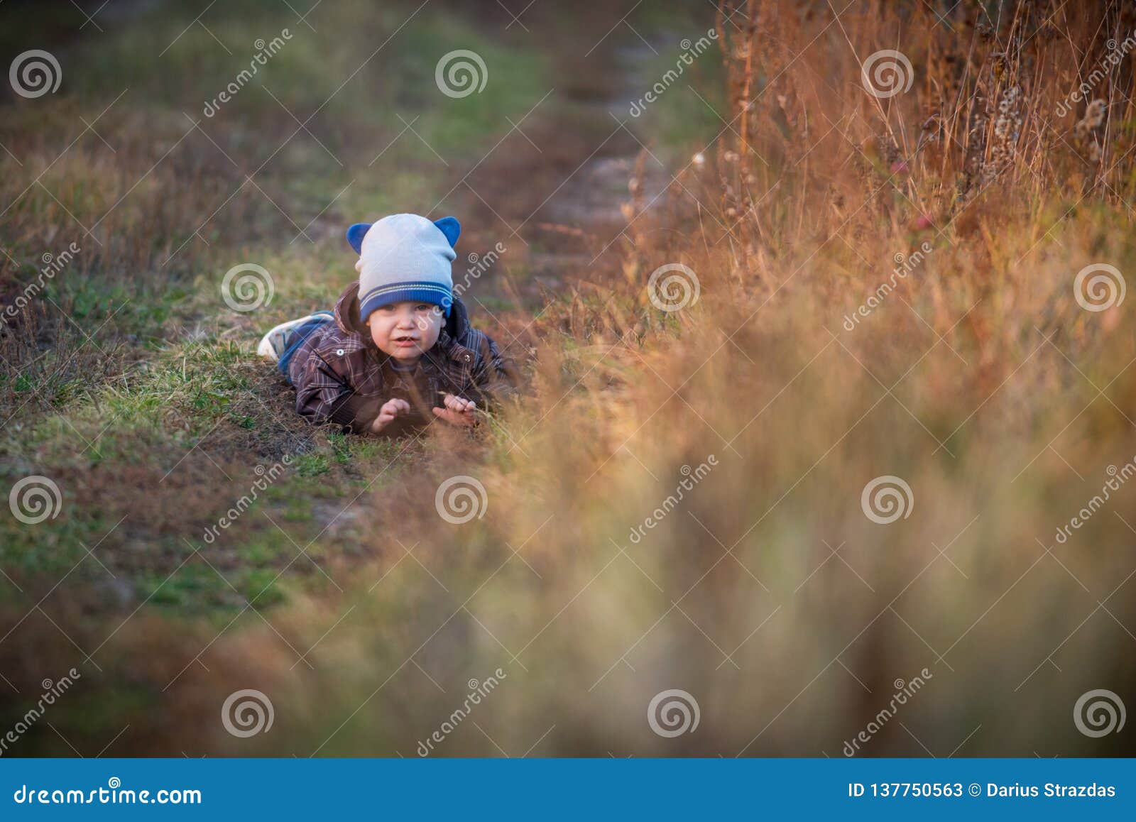 Child lying on a ground stock image. Image of jacket - 137750563