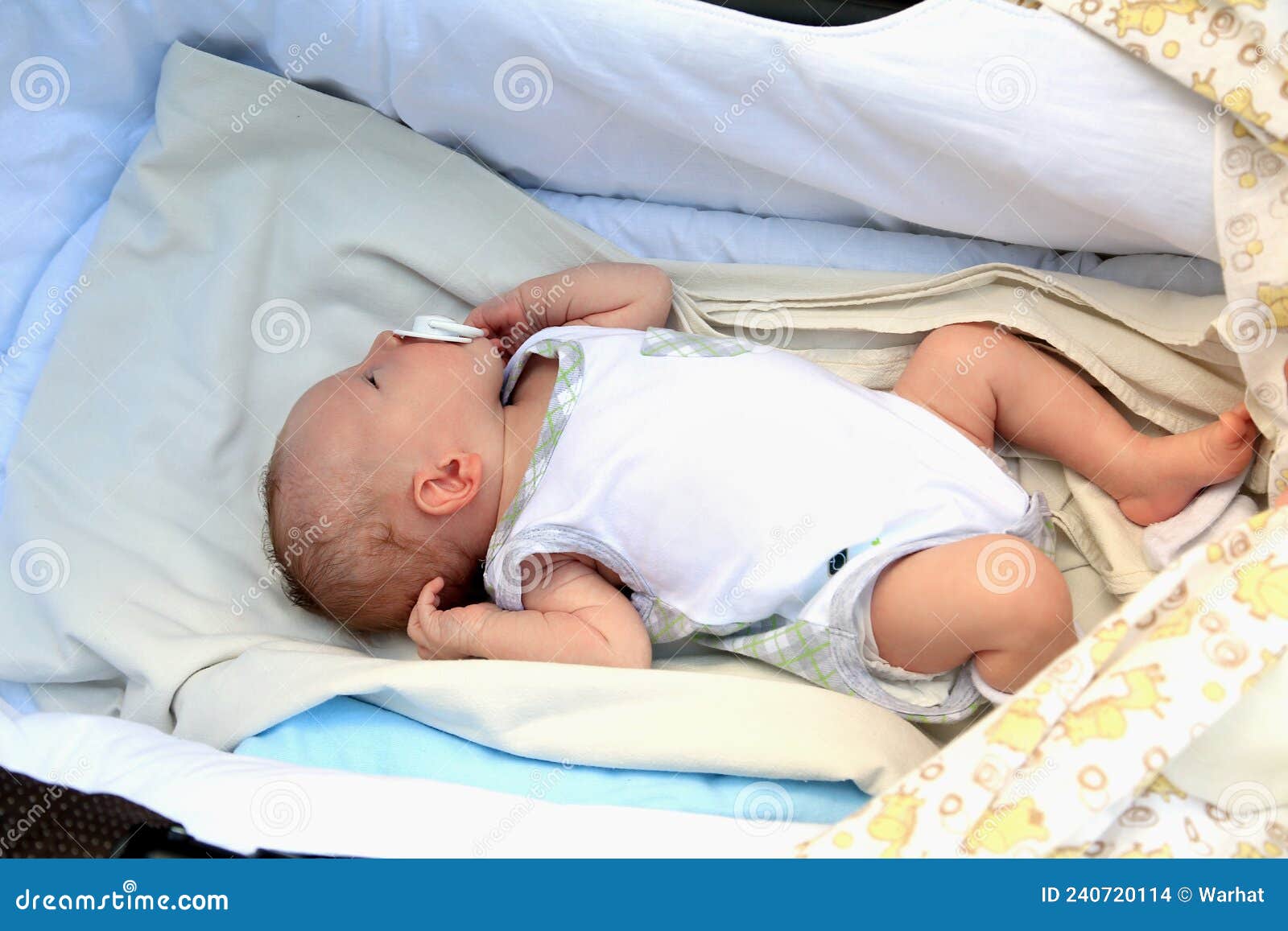 A Child is Lying in a Stroller with a Pacifier in His Mouth Stock Photo ...