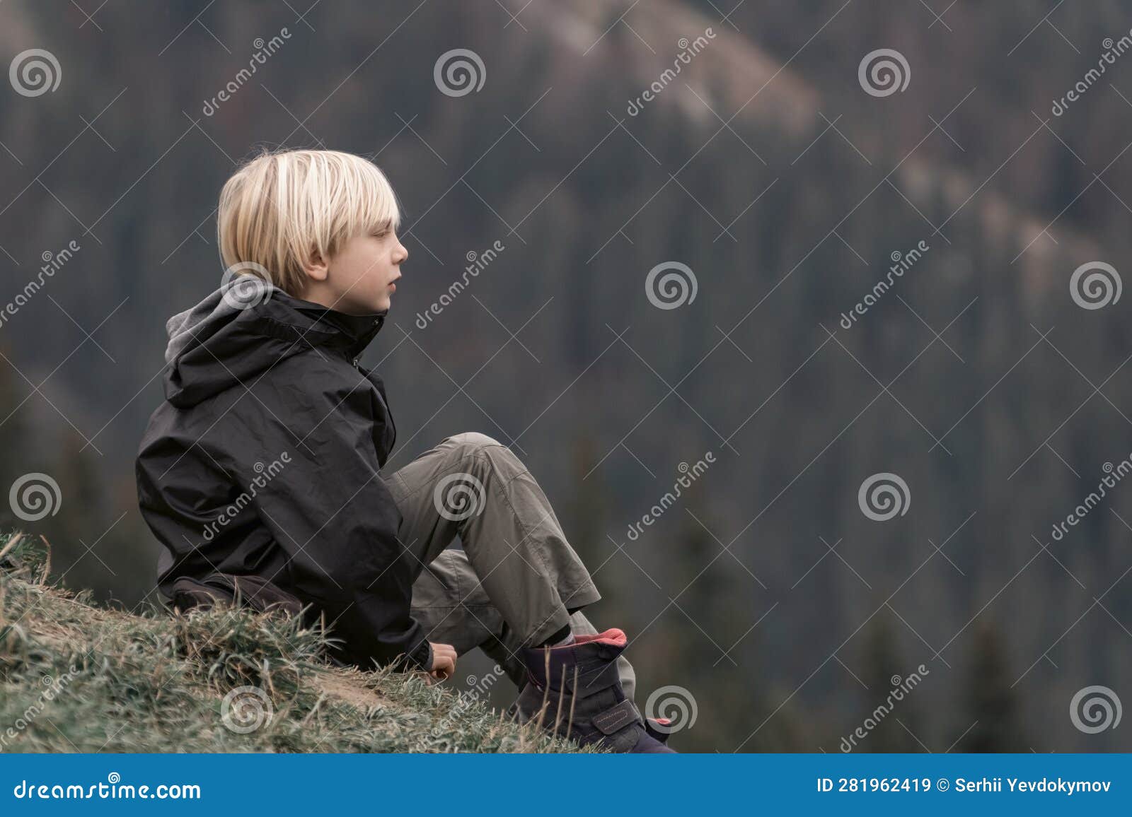 Child on the Mountainside. Sad Brooding Blond Boy in Trekking Clothes ...
