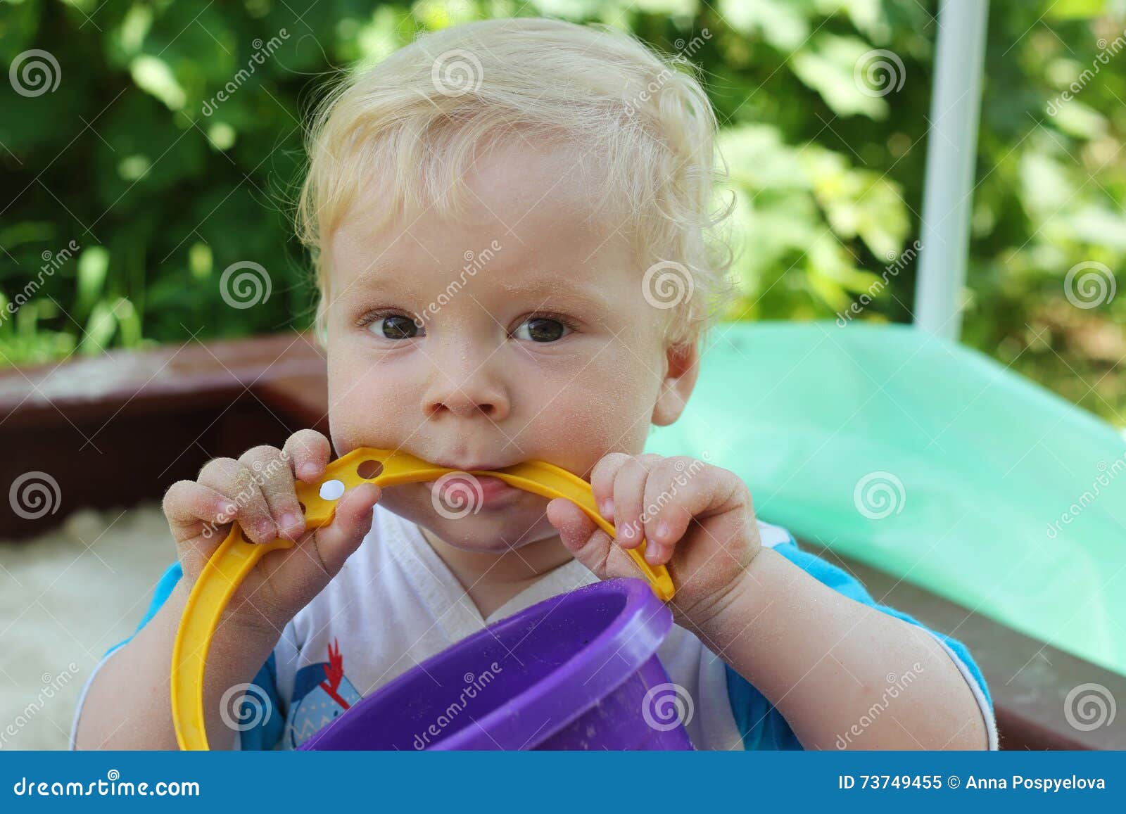 A Child Nibbles Bucket Handle Stock Image - Image of summer, outdoor ...