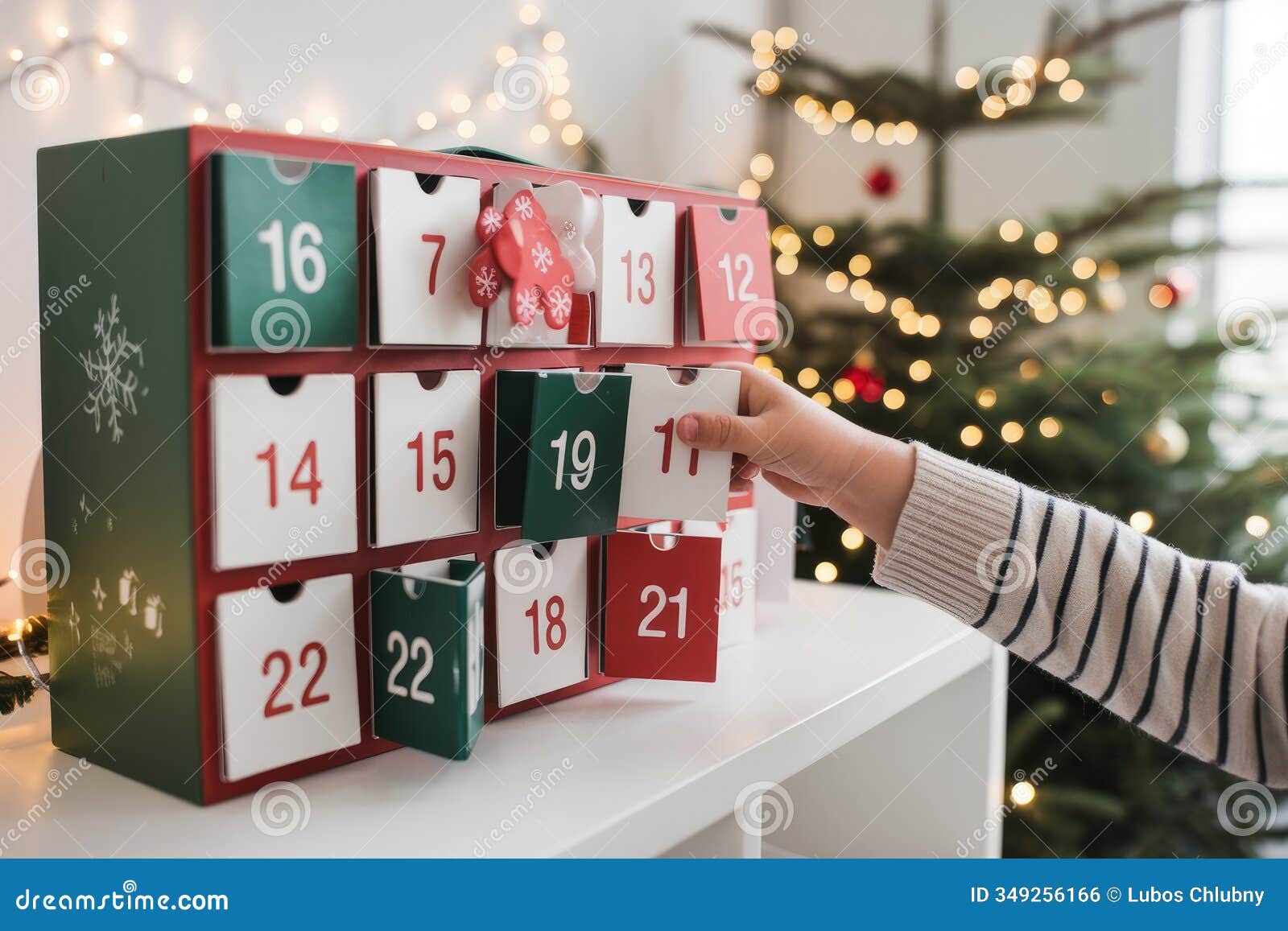Child Opening Box of Advent Calendar with Christmas Tree in Background ...