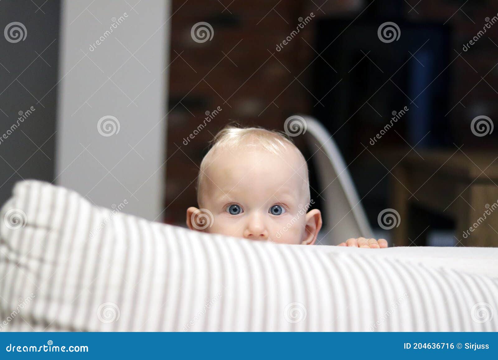 A Child Peeking Out Form Behind a Pillow with a Surprised Face ...