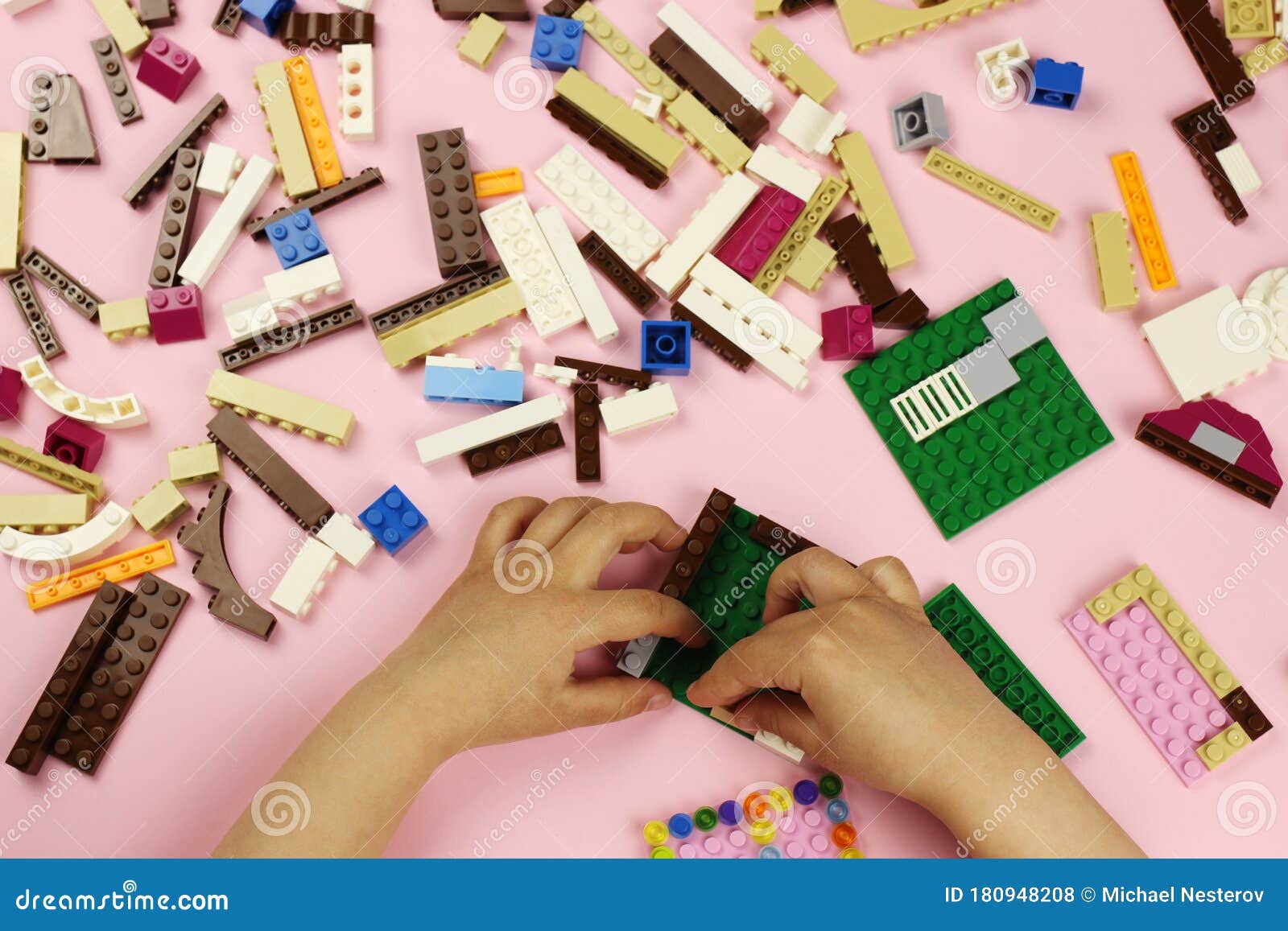 Child Playing with Colored Blocks on a Pink Background, Hands Close-up ...