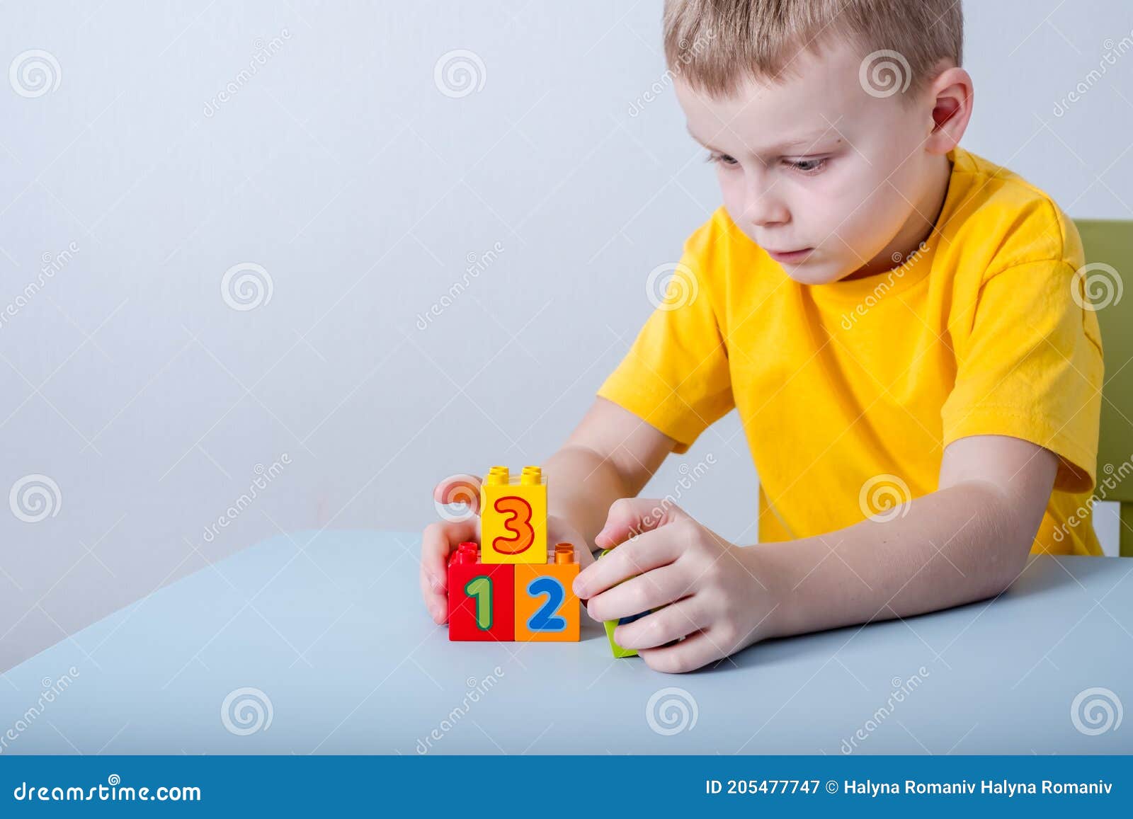 The Child Playing with Cubes with Numbers on the Table.on a White ...