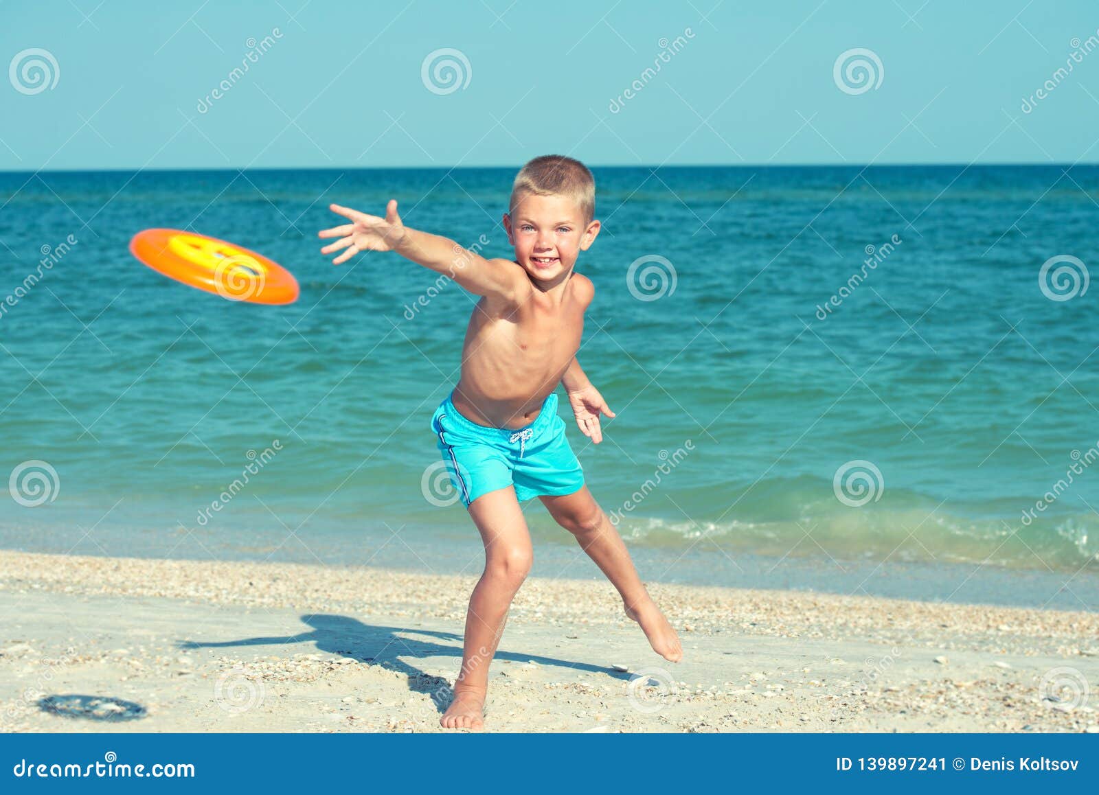 A Child is Playing with a Frisbee on the Beach. Stock Image - Image of ...