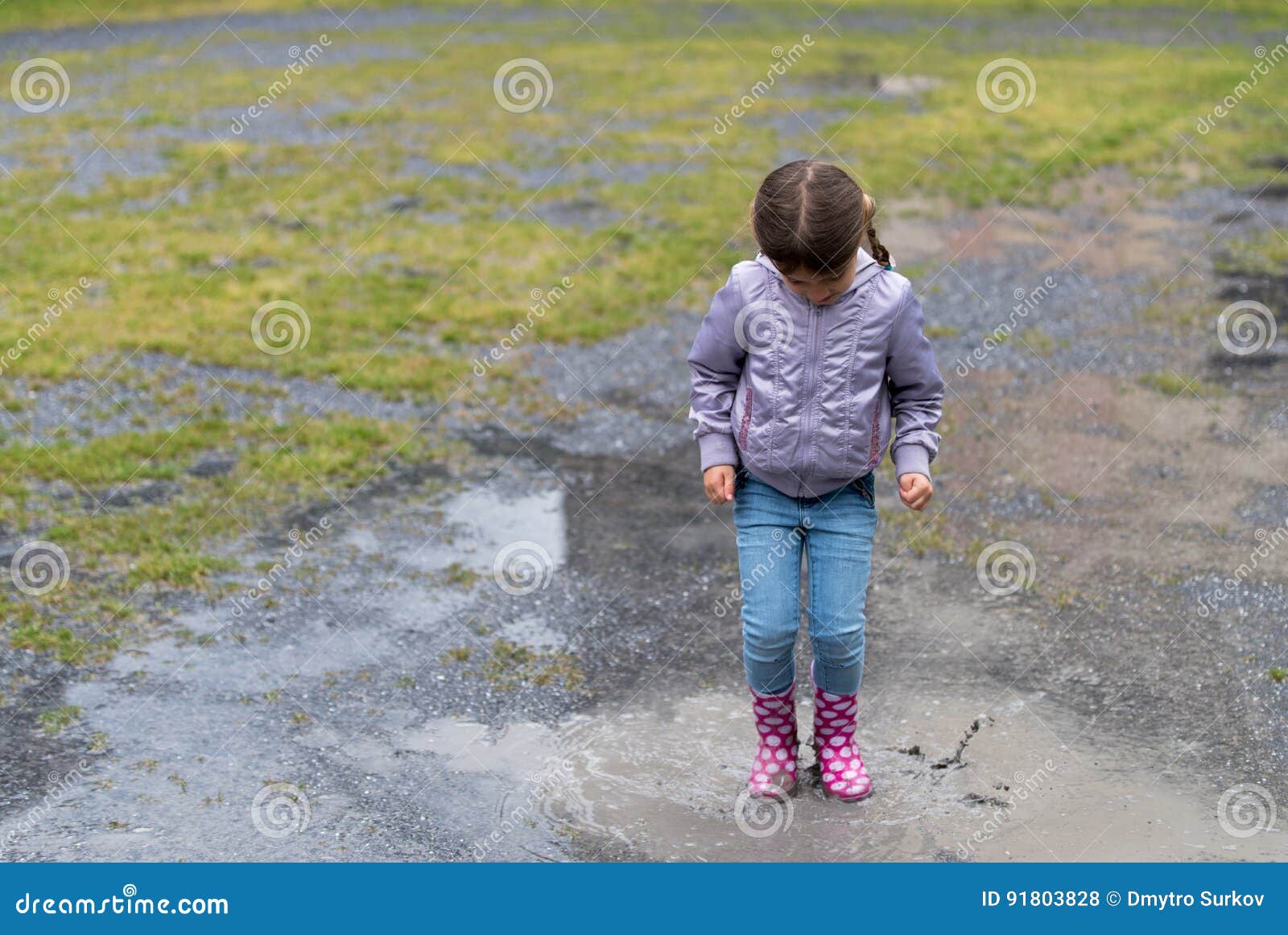 The Child Playing in a Puddle Stock Photo - Image of holding, jeans ...
