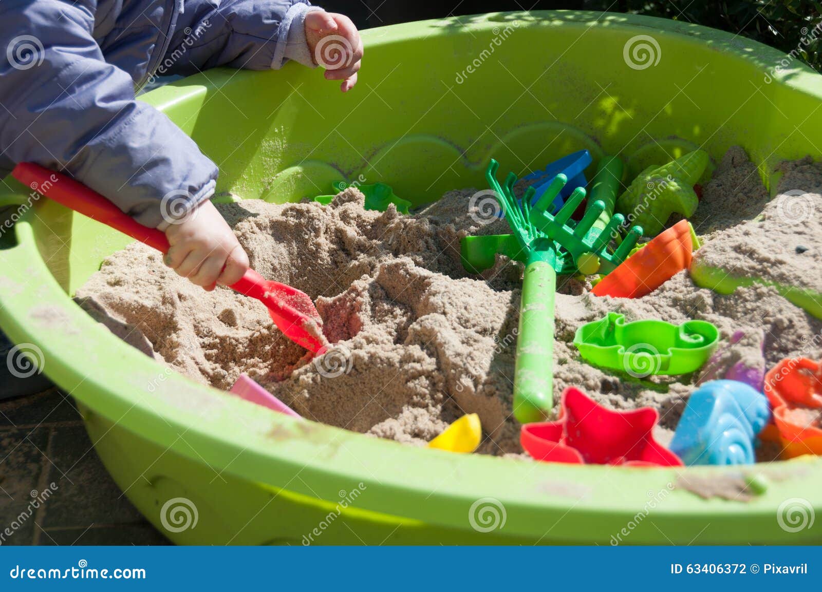 Child playing in sandbox stock photo. Image of background - 63406372
