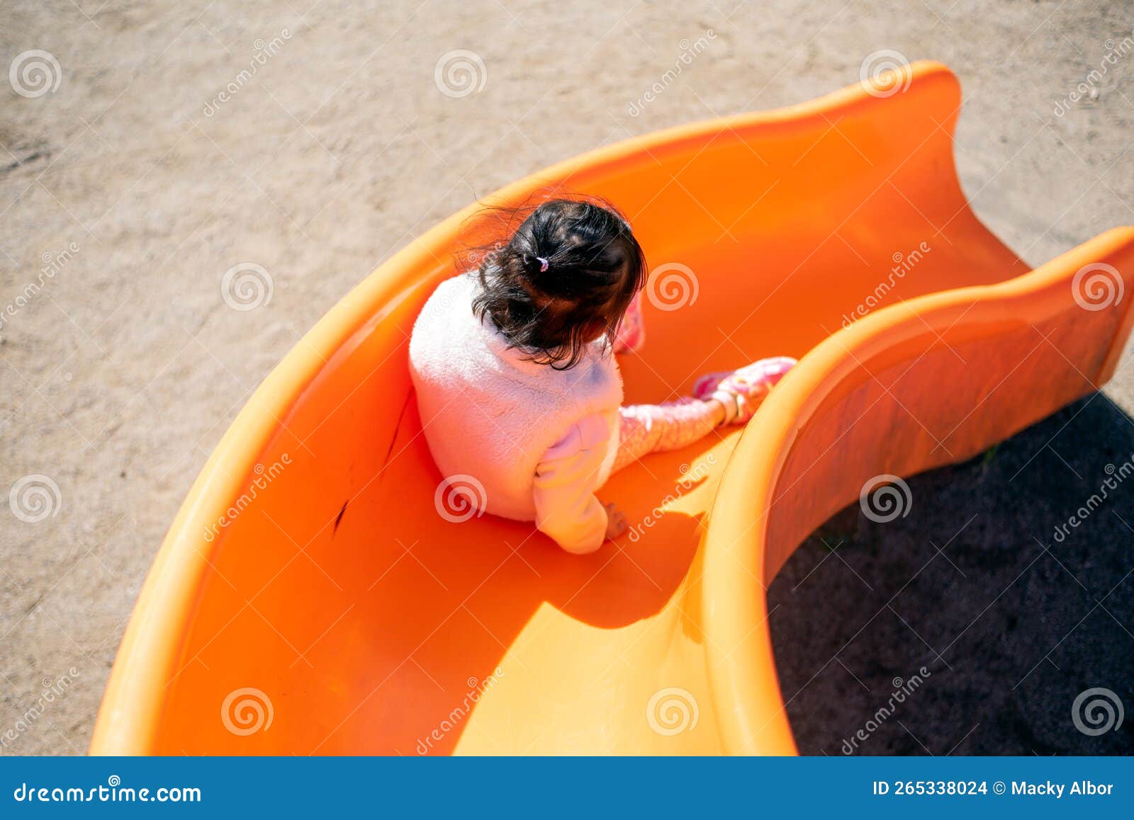 A Child Playing on a Slide at a Playground. Stock Photo - Image of ...