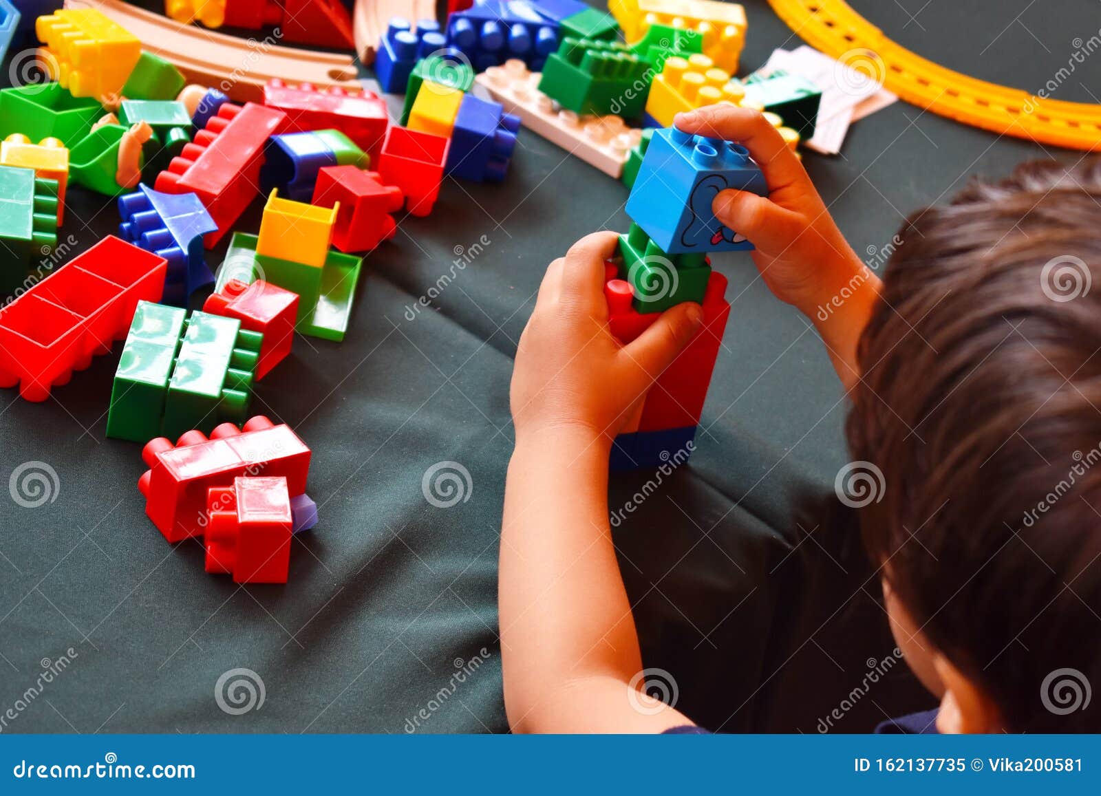 A Child Plays with Colored Cubes. Children`s Plastic Multi-colored ...