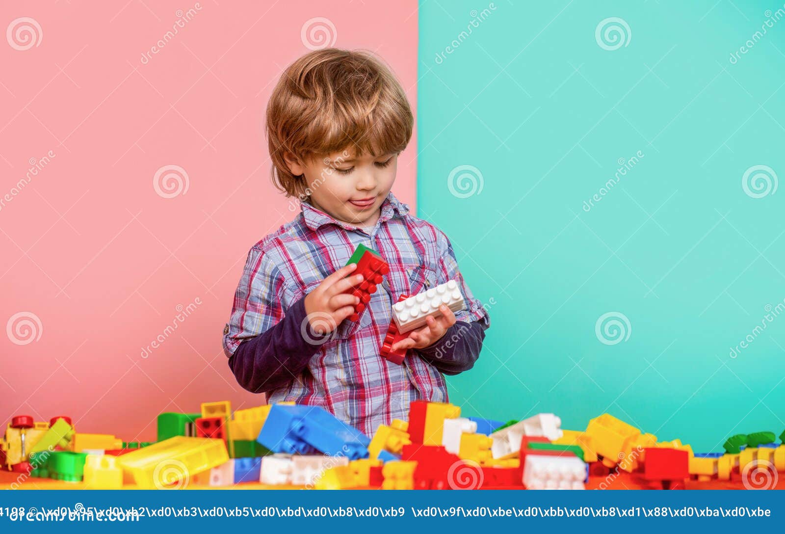 The Child Plays with Colorful Plastic Toy Bricks on the Table. Boy ...