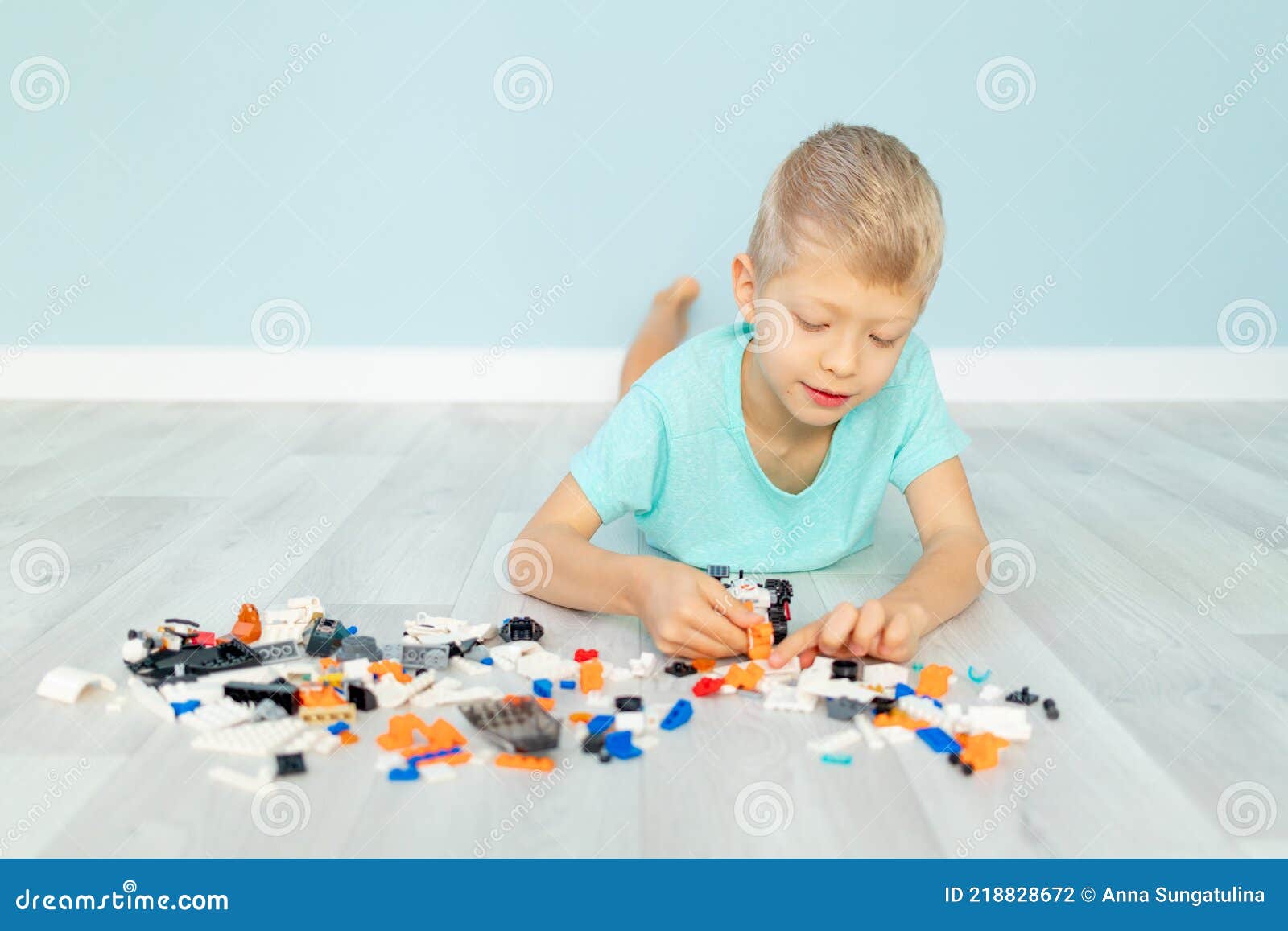 A Child Plays with a House Constructor on a Blue Background Stock Photo ...