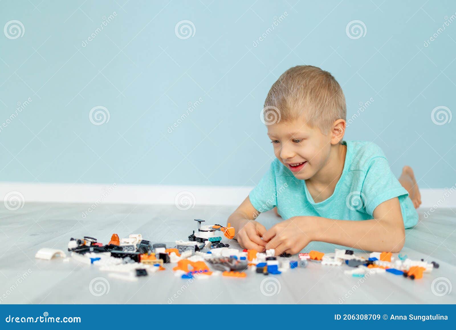 A Child Plays with a Lego House Constructor on a Blue Background Stock ...