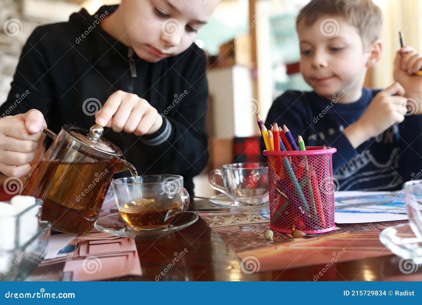 Child pouring tea in cafe stock photo. Image of cafe - 215729834