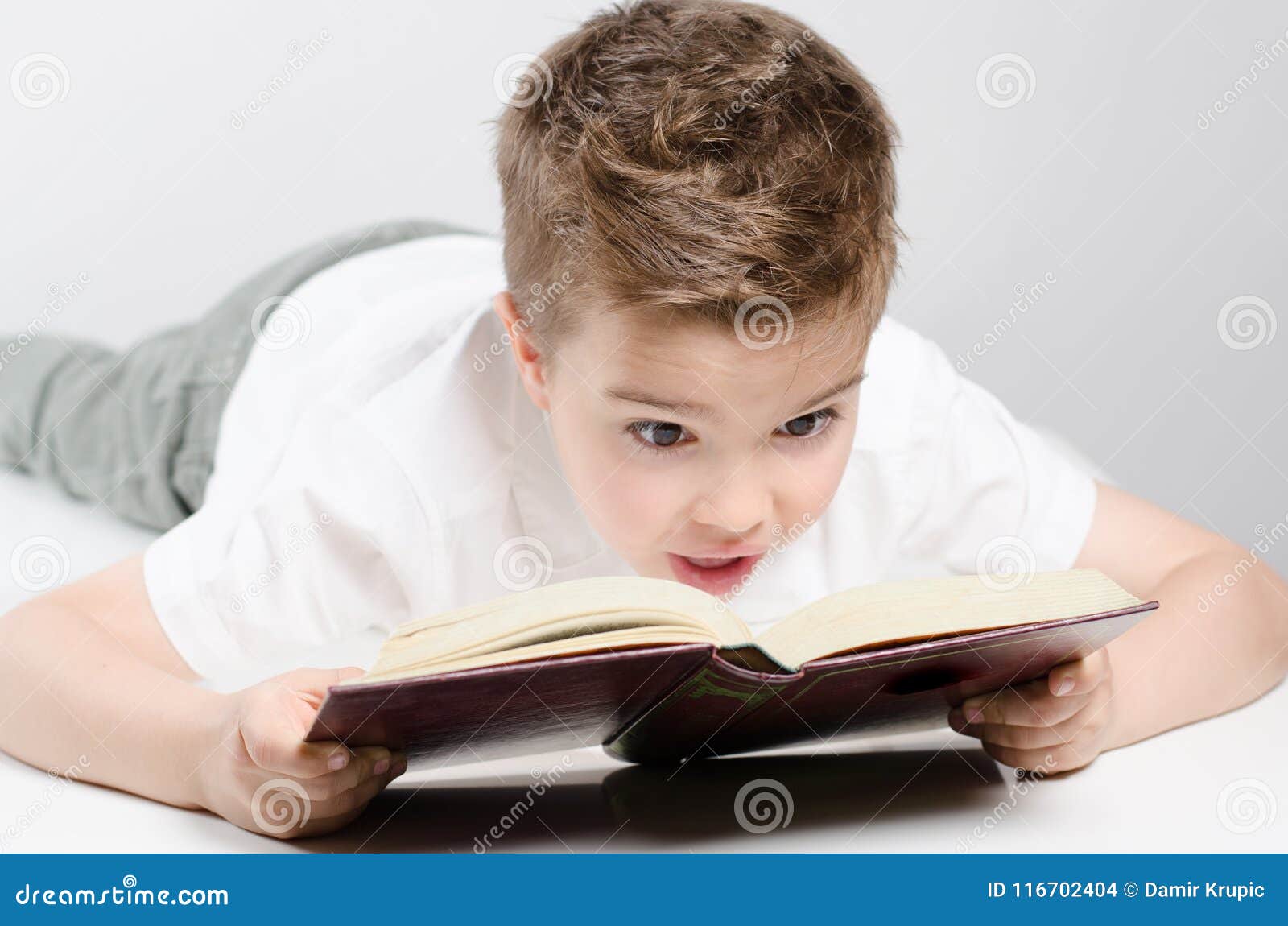 A Child is Reading a Book Lying Stock Photo - Image of think, table ...