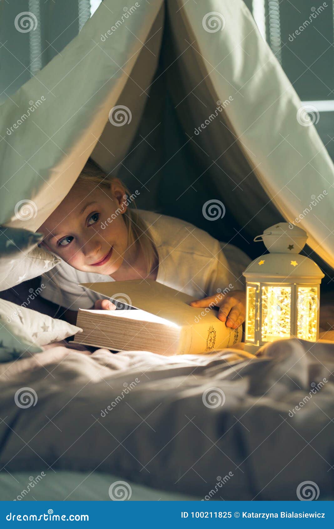 Child reading book in tent stock image. Image of dark - 100211825