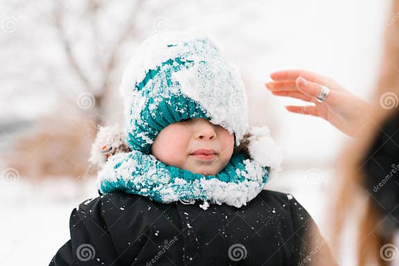 Child S Face is Covered in Snow, and the Hat is Pulled Down Over the ...