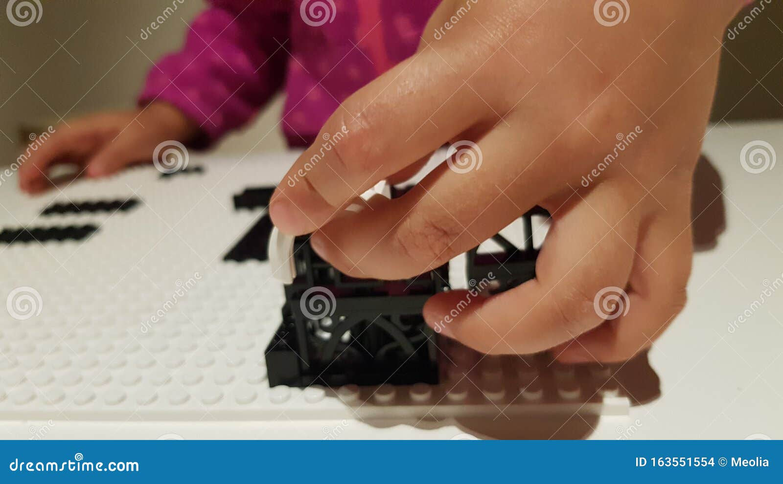 Child& X27;s Hand is Attaching a New Lego Piece To the Construction ...