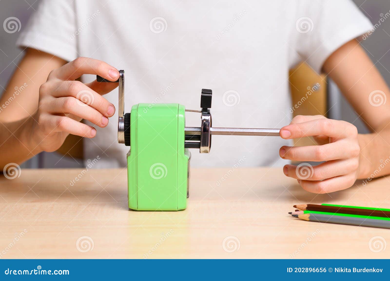 A Child Sharpens Pencils with a Mechanical Sharpener Stock Photo ...