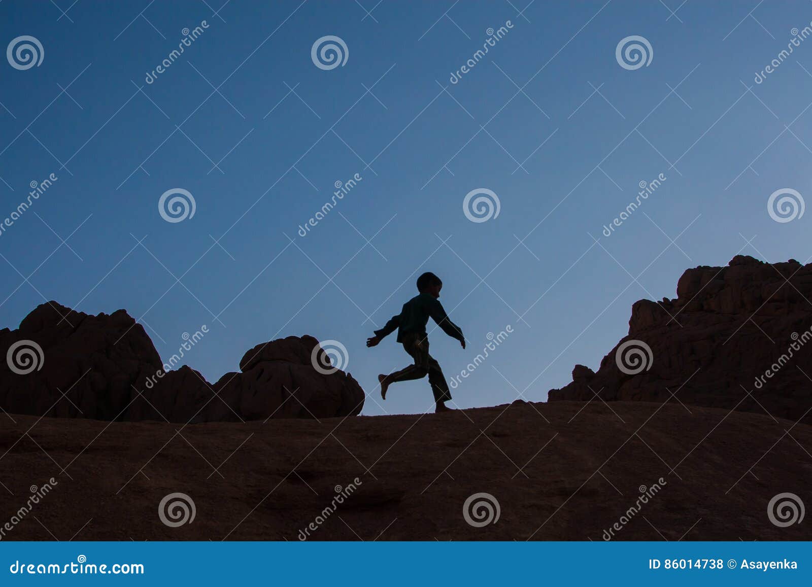 Child Silhouette Running Over the Rocks in the Desert at Sunset Stock ...