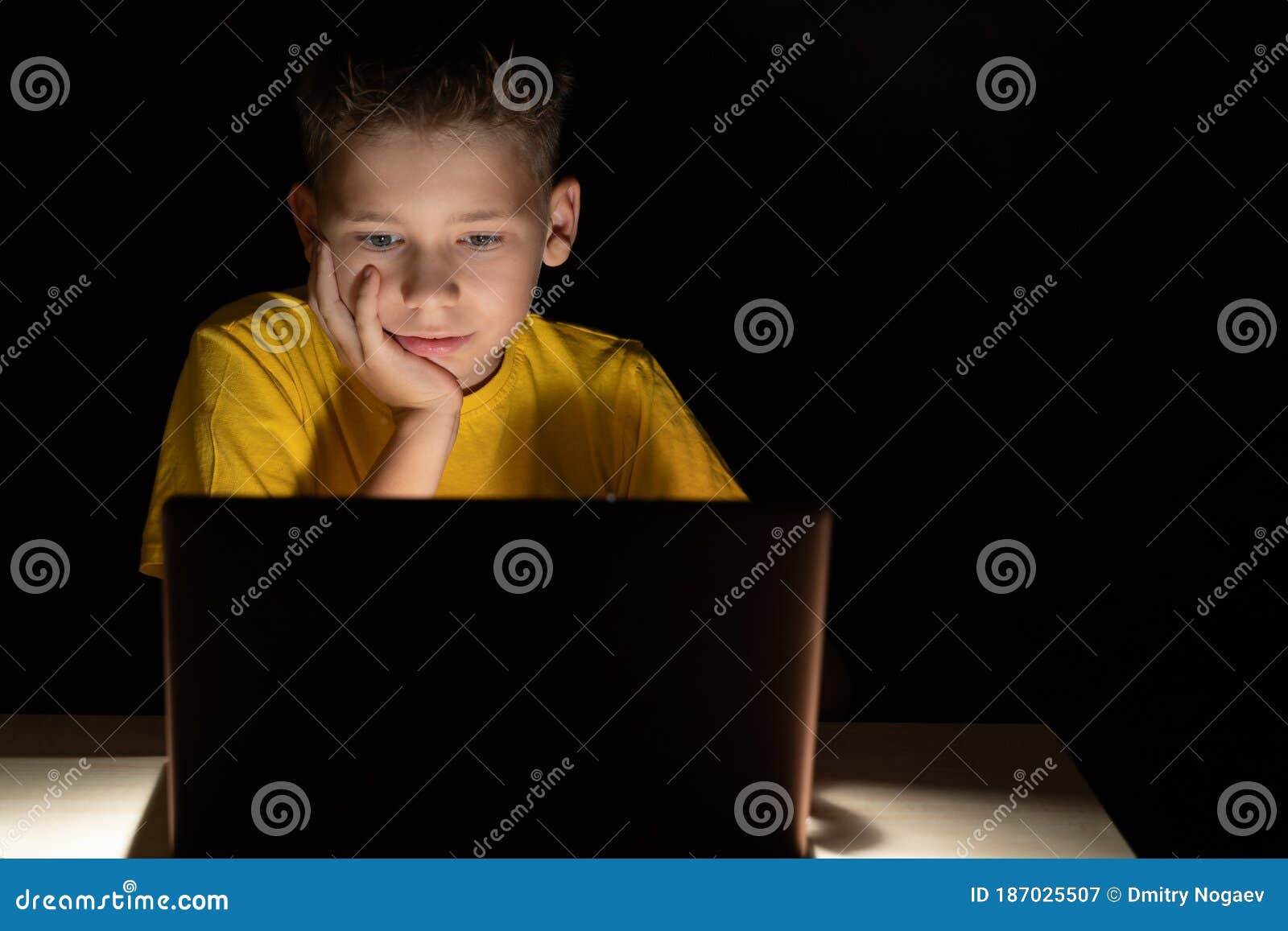 The Child Sits in the Dark at the Table and Looks at the Laptop Stock ...