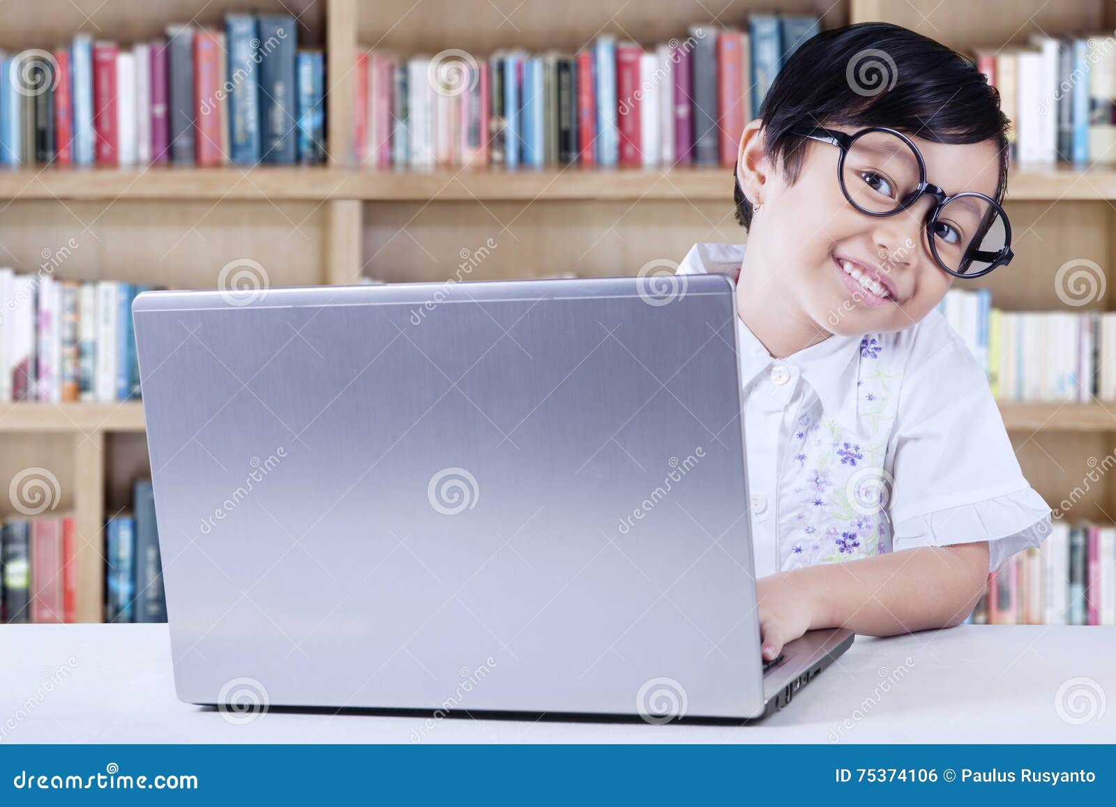 Child Sits in the Library with Laptop Stock Photo - Image of little ...