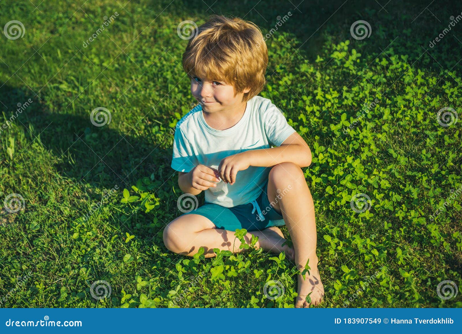 A Child is Sitting on the Grass. Happy Sunny Day Outside. Stock Image ...