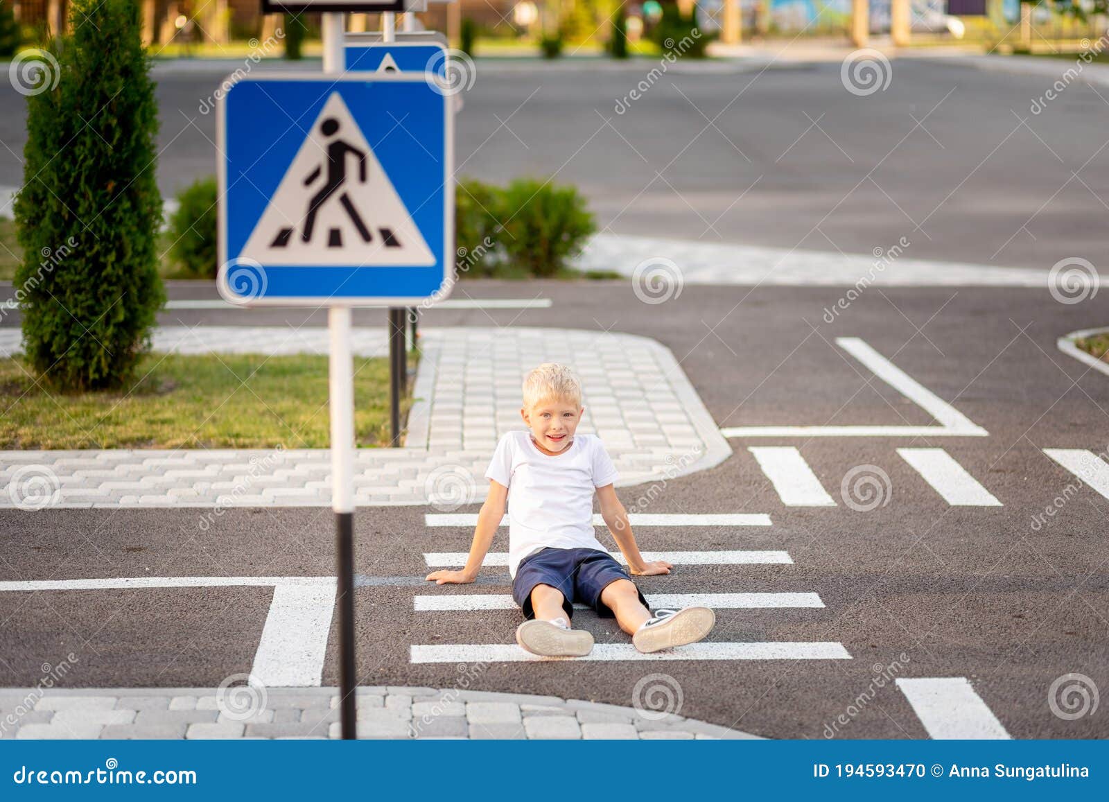 A Child Is Sitting On The Road At A Pedestrian Crossing Among Road ... A Child Is Sitting On The Road At A Pedestrian Crossing Among Road ...