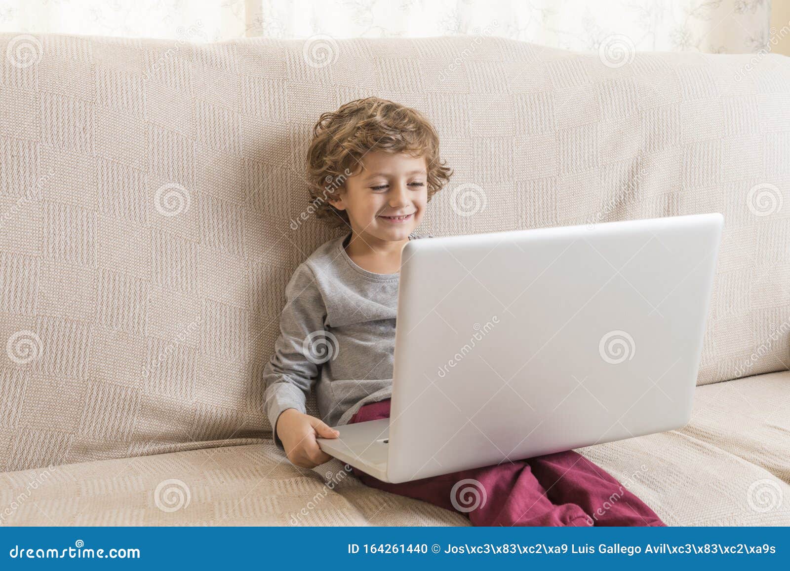 Child Sitting on a Sofa Watching a Laptop Stock Photo - Image of ...