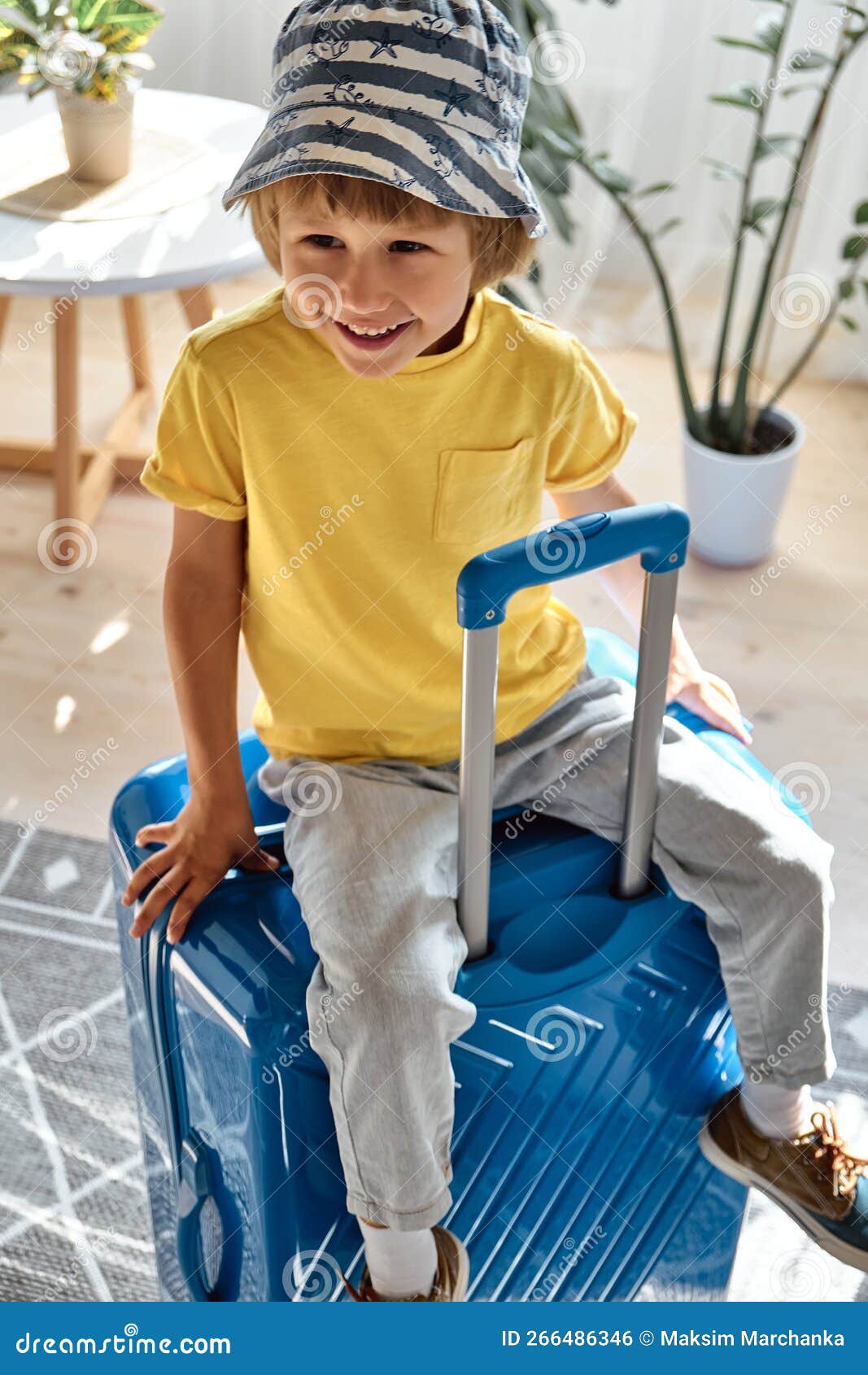 A Child Sitting on a Suitcase Have Fun and Laughs, Waiting for a Trip ...