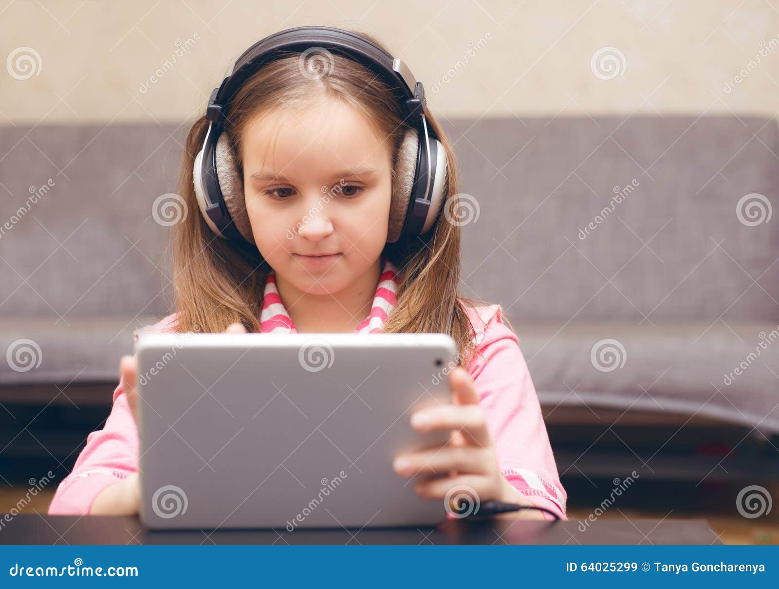 A Child Sitting at a Table in the Large and Looks at the Computer Stock ...