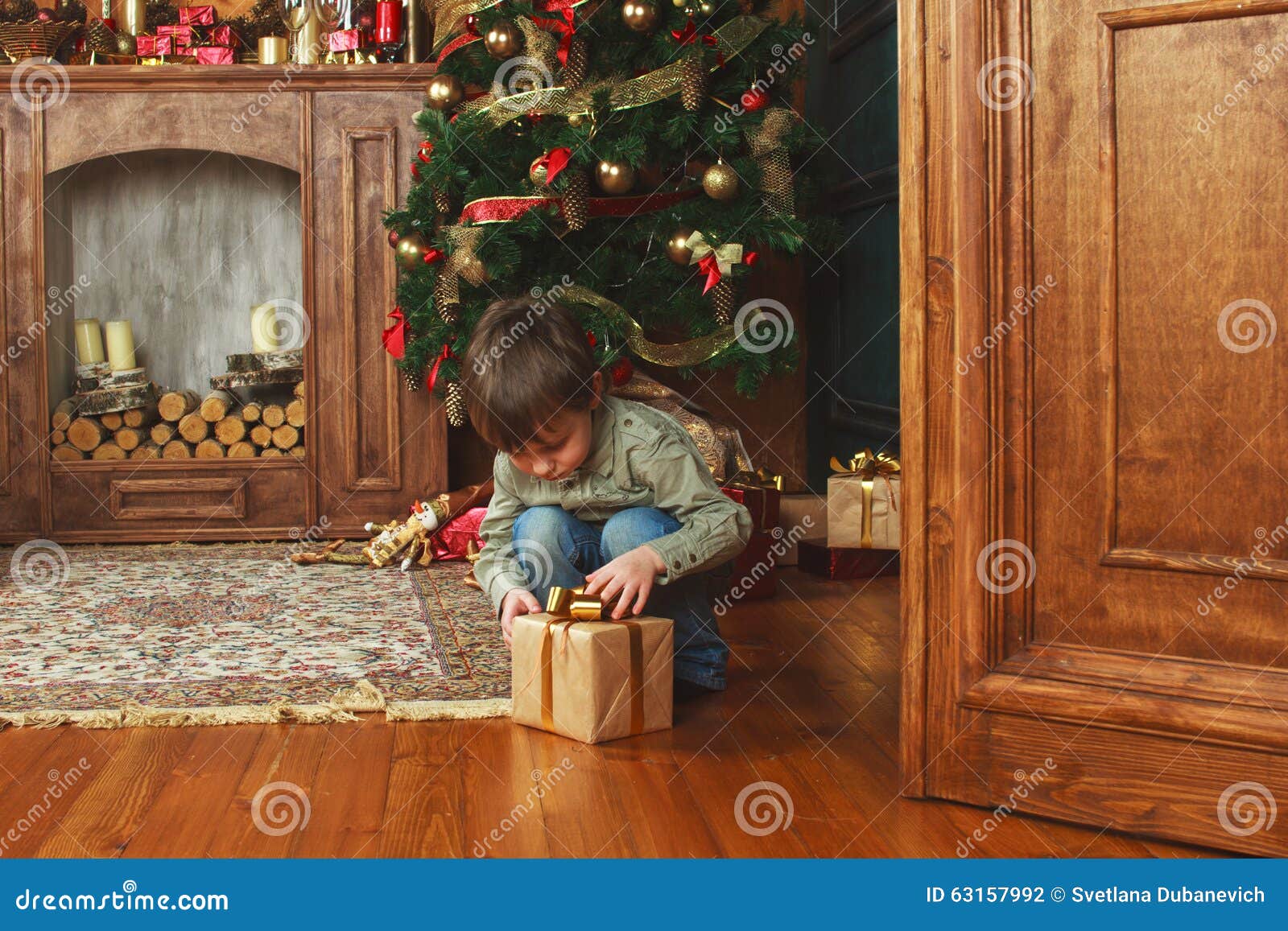 Child Sitting Under the Christmas Tree with Gifts Stock Photo - Image ...