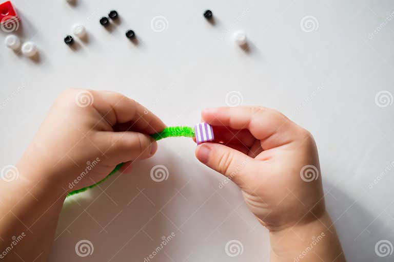 Child Stringing Beads on String. Development of Baby`s Fine Motor ...