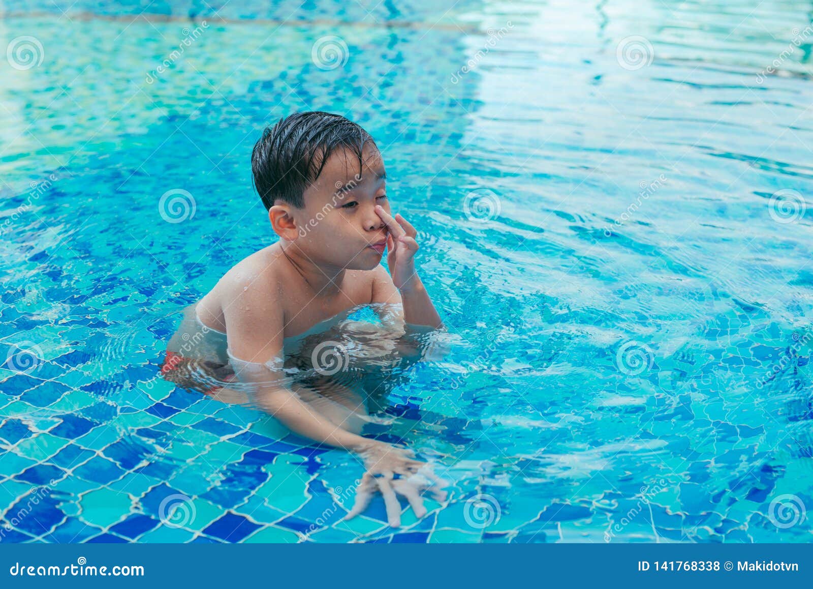Child at the Swimming Pool Steps, Rubbing Water from His Eyes Stock ...