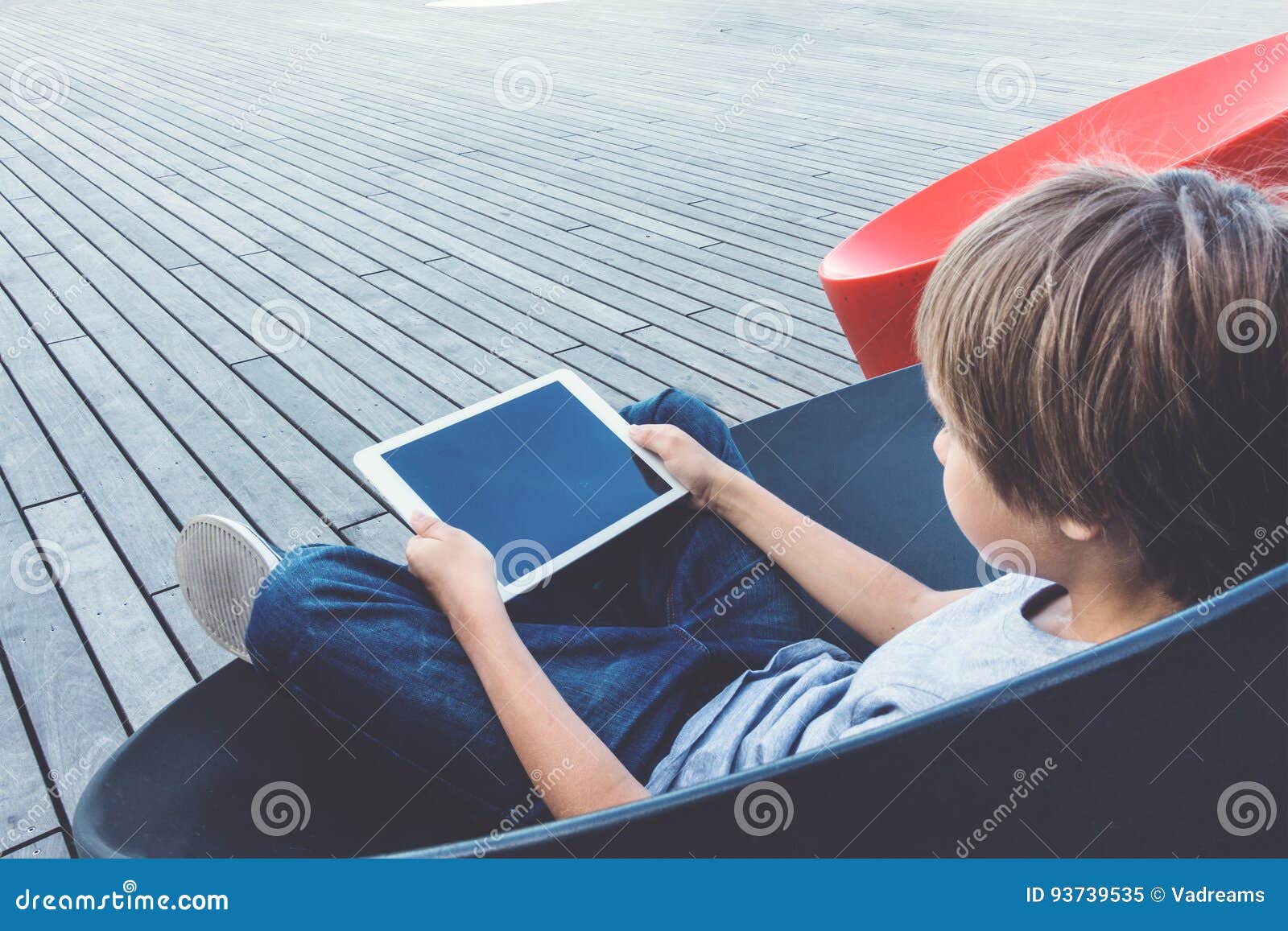 Child with Tablet Computer Sitting Outdoors. Stock Image - Image of ...