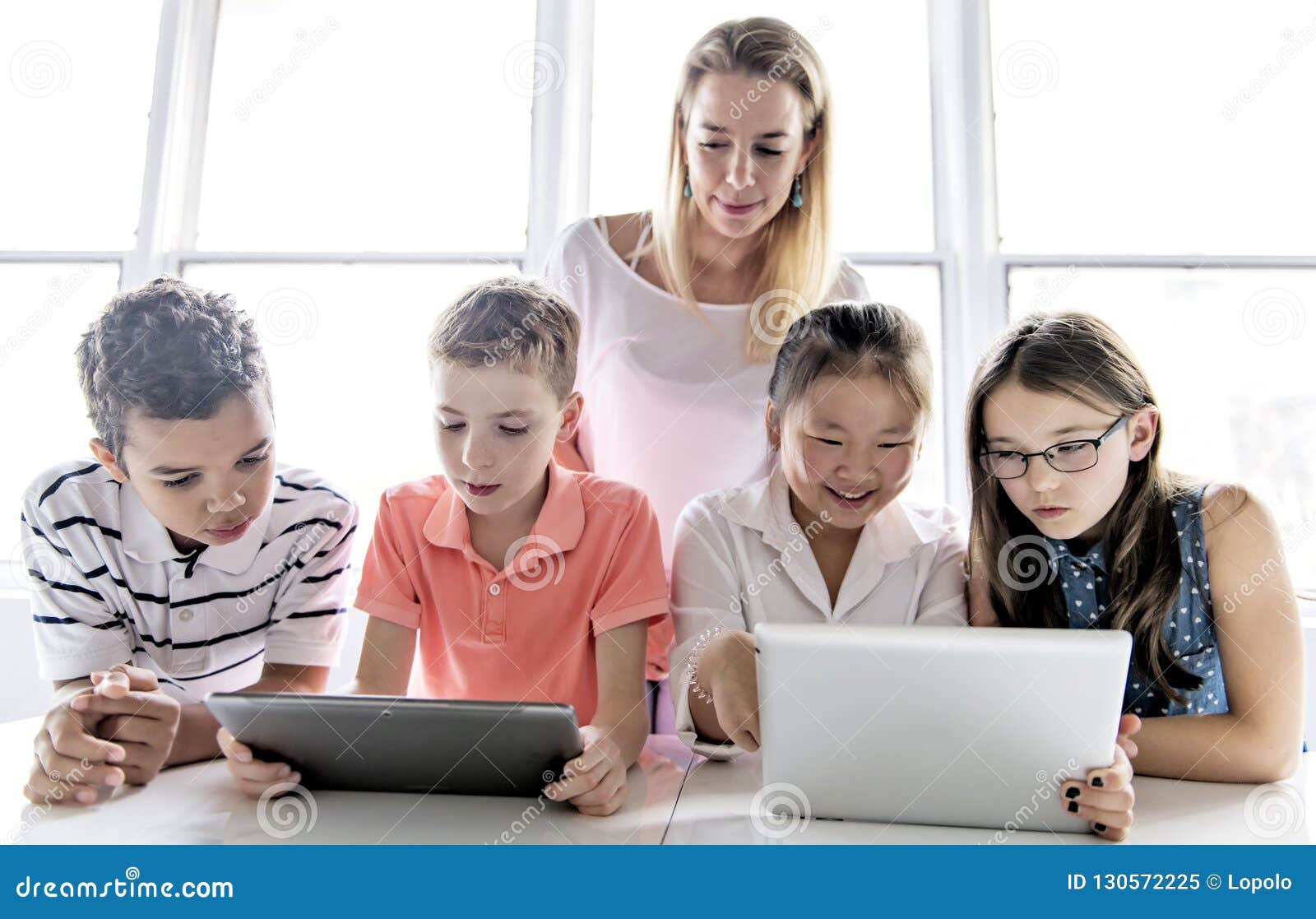 Child with Technology Tablet and Laptop Computer in Classroom Teacher ...